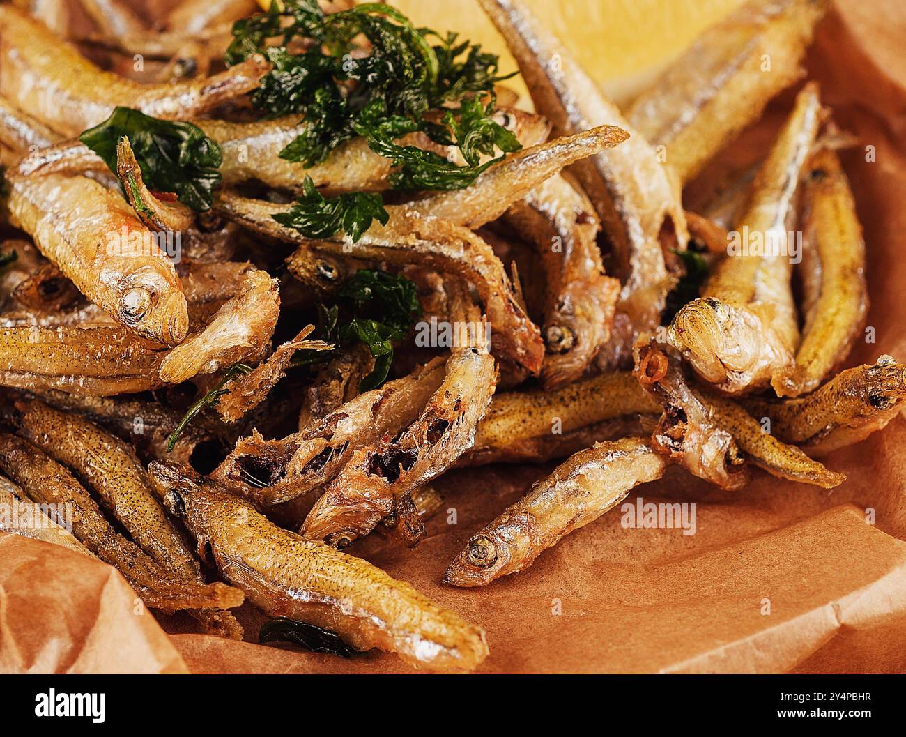 Hot fried smelt fish with salt and herbs on brown paper Stock Photo - Alamy
