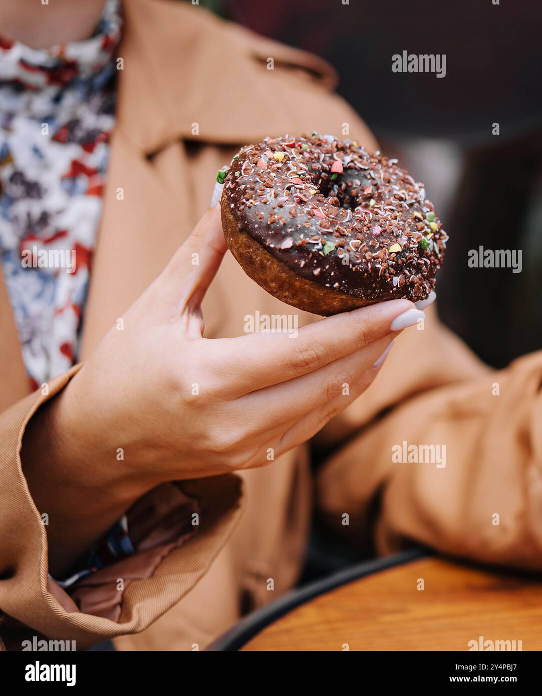 Female hands are holding a donut Stock Photo - Alamy