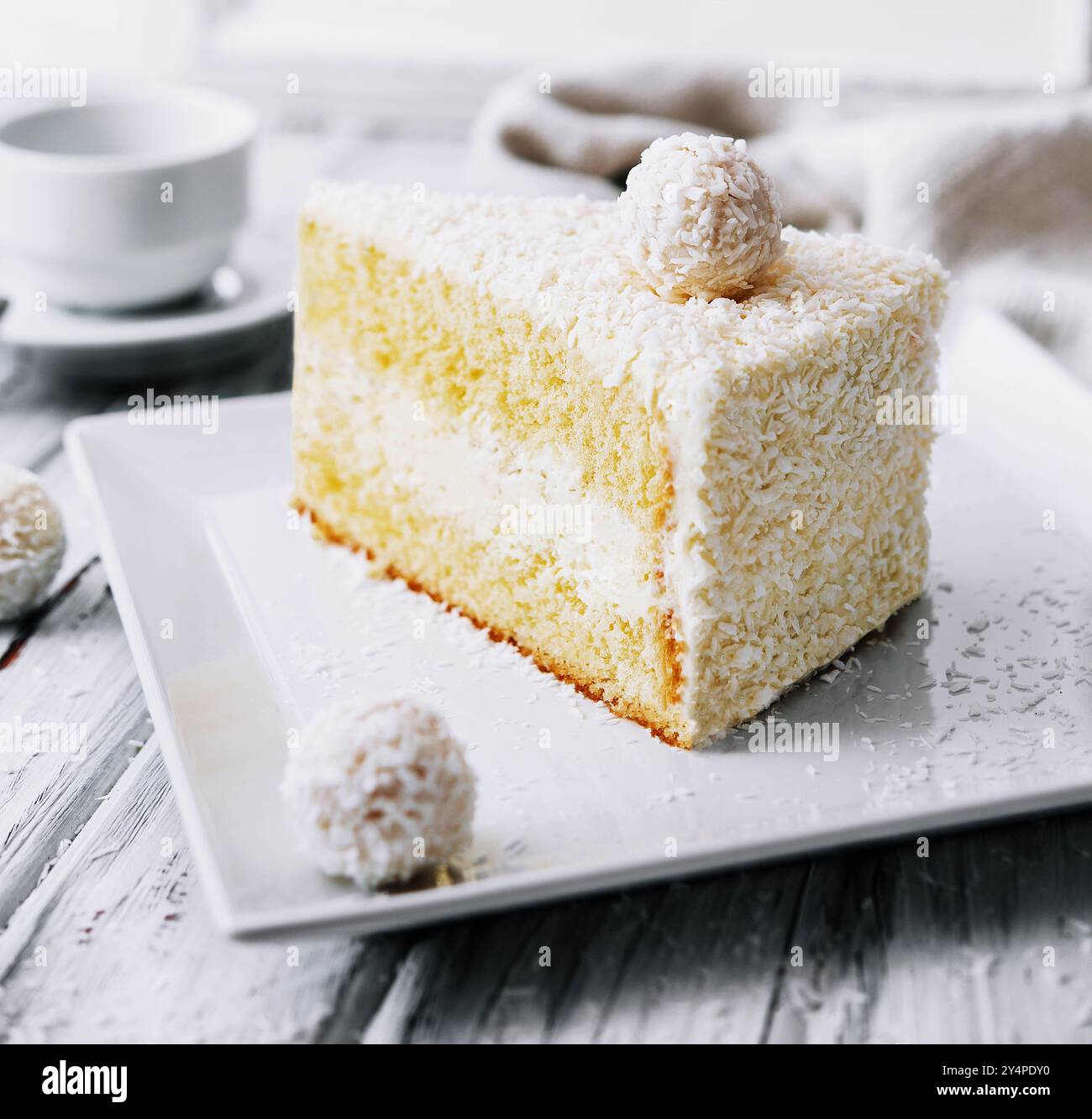 Coconut layered, raffaello cake on white plate Stock Photo - Alamy