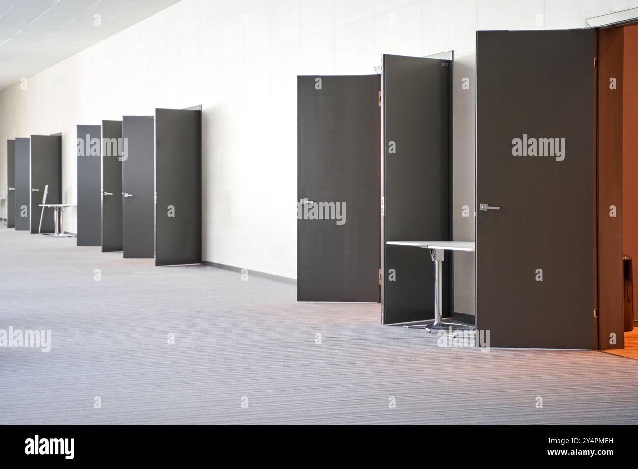 Modern office corridor with open doors creating a minimalistic and ...