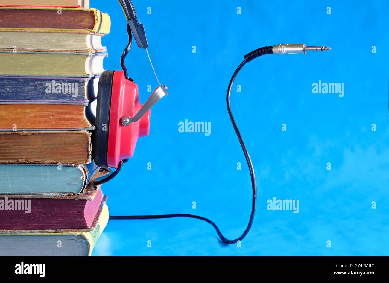 audiobooks concept with books vintage headphonesand audio plug.Bright ...
