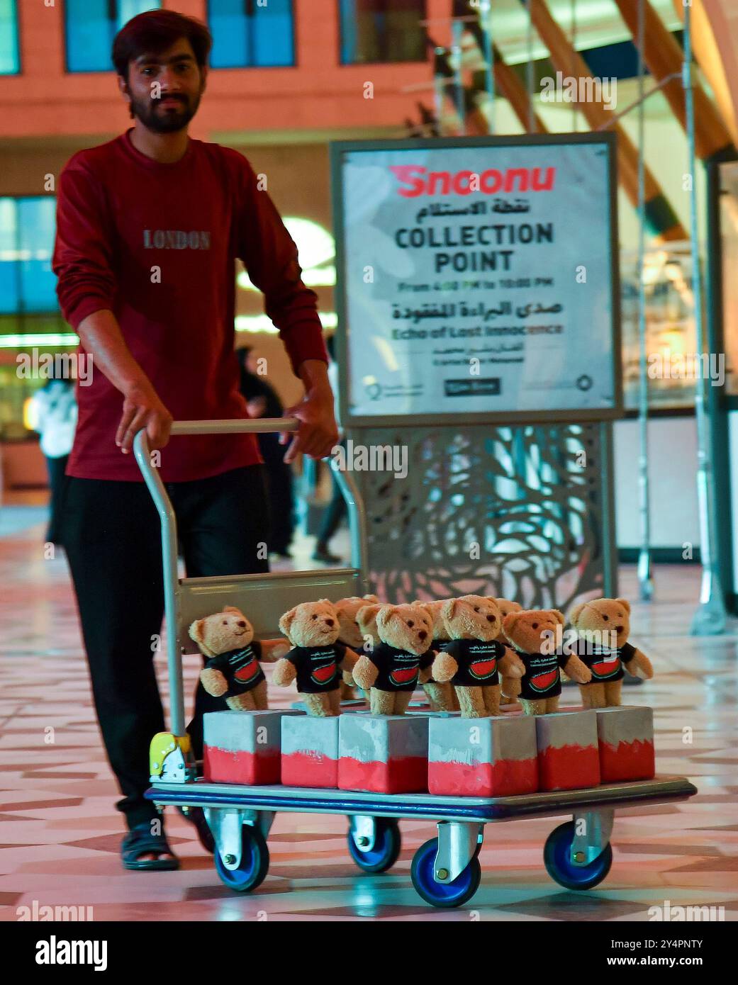 A volunteer carries teddy bears during the installation of ''Echo of ...