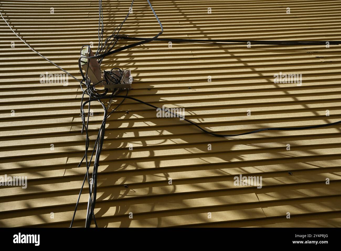 tangle of utility wires on the side of a residential building Stock ...