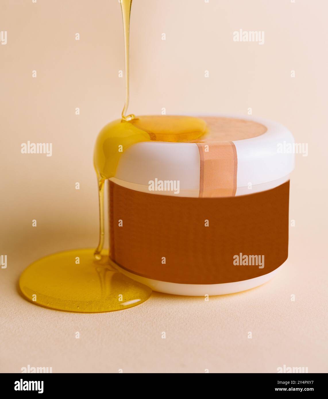 Honey drips into natural spa formula for skincare Stock Photo - Alamy