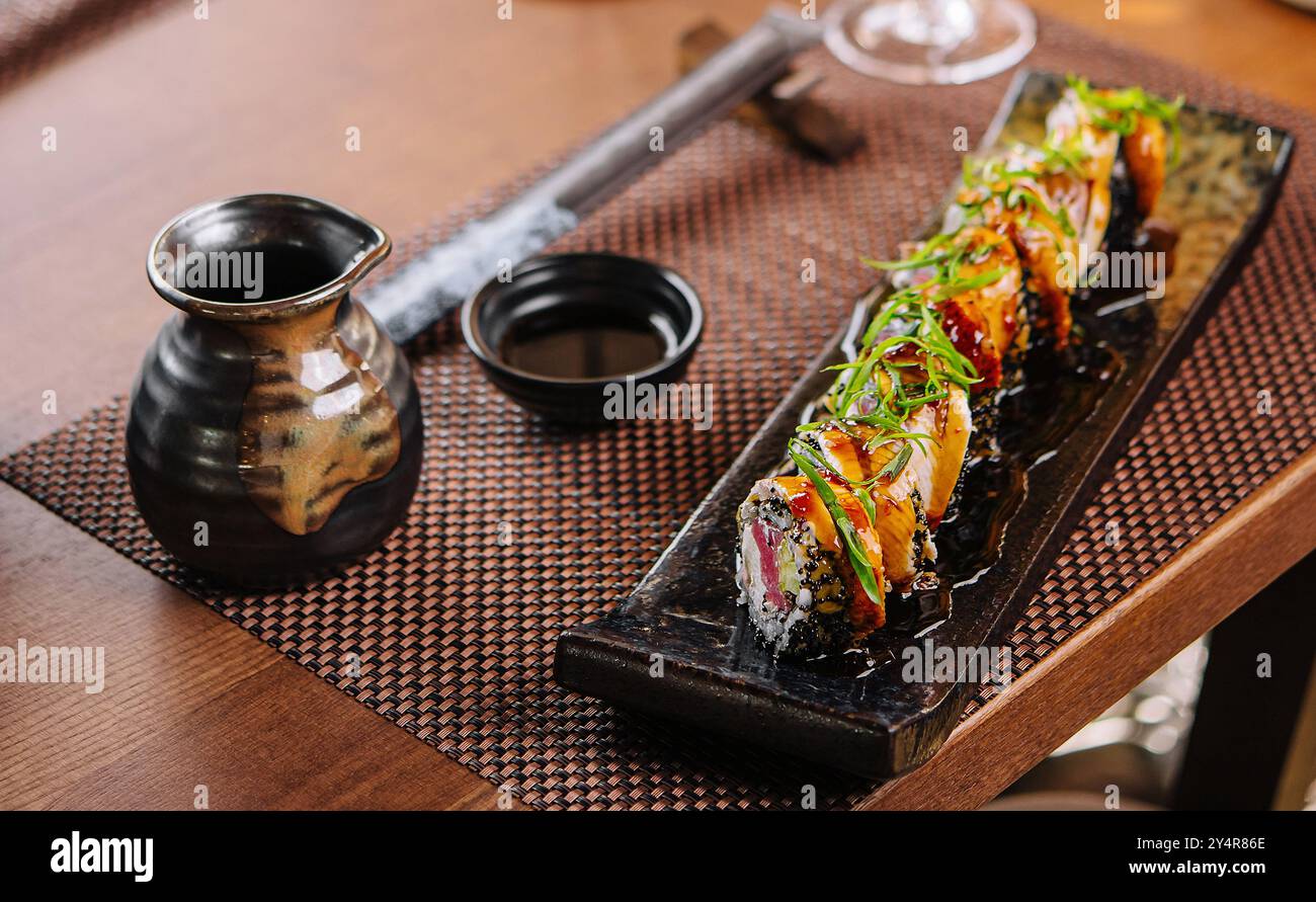 Japanese unagi eel grilled sushi maki roll cutting Stock Photo - Alamy