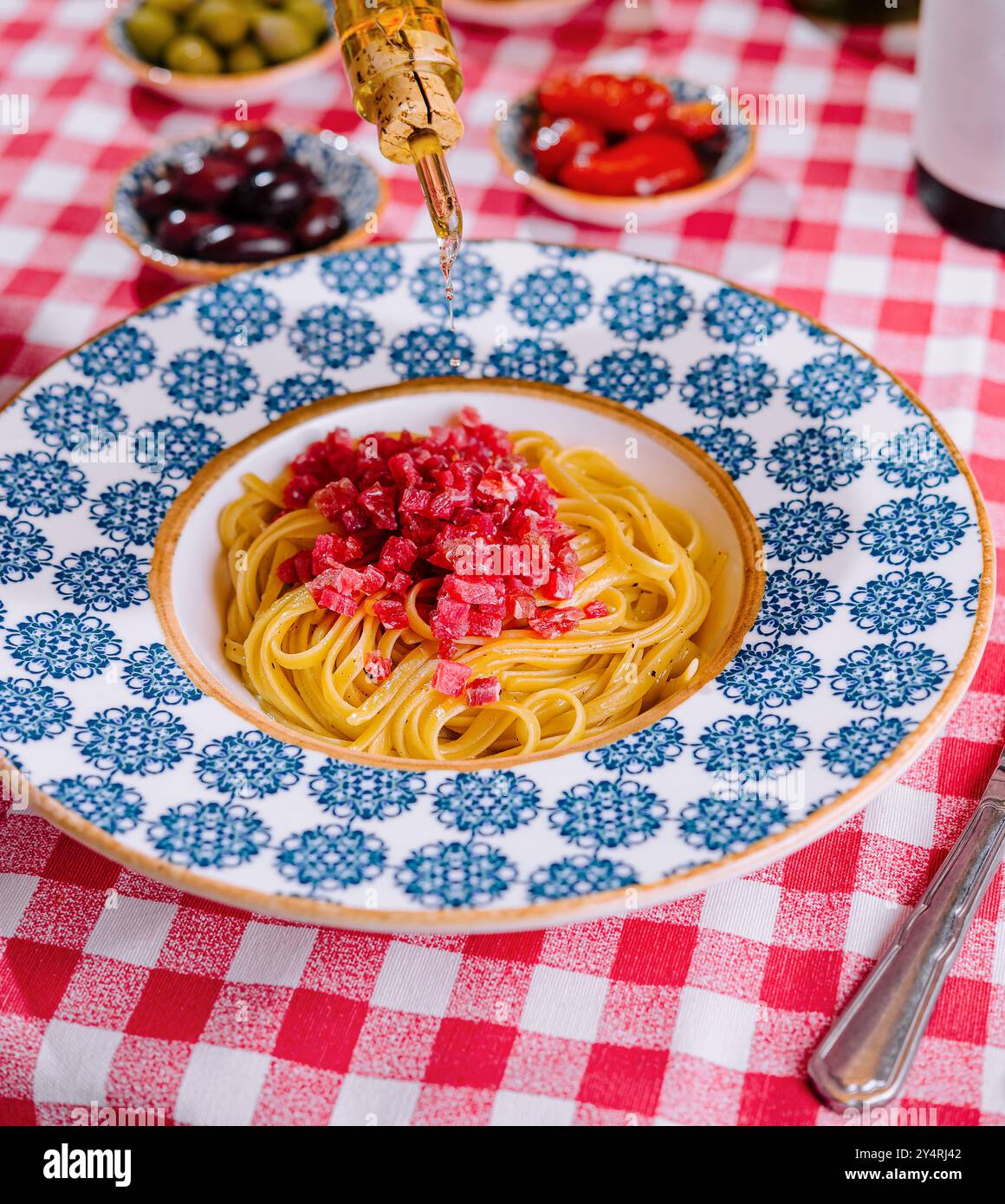 chef pouring olive oil on spaghetti Stock Photo - Alamy
