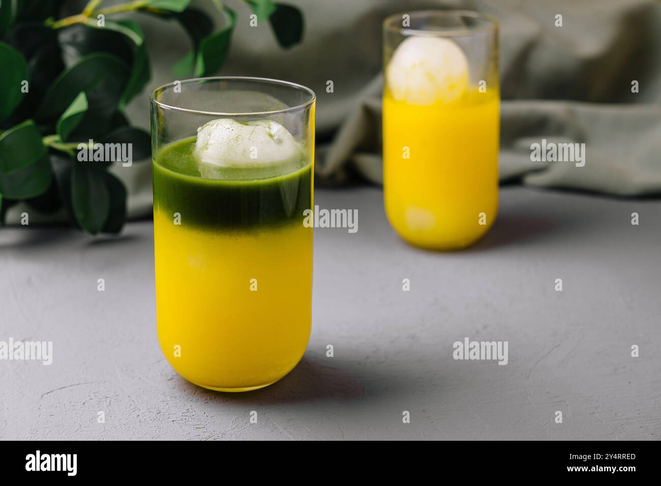 Vibrant green matcha float beside a glass of fresh mango juice on a ...