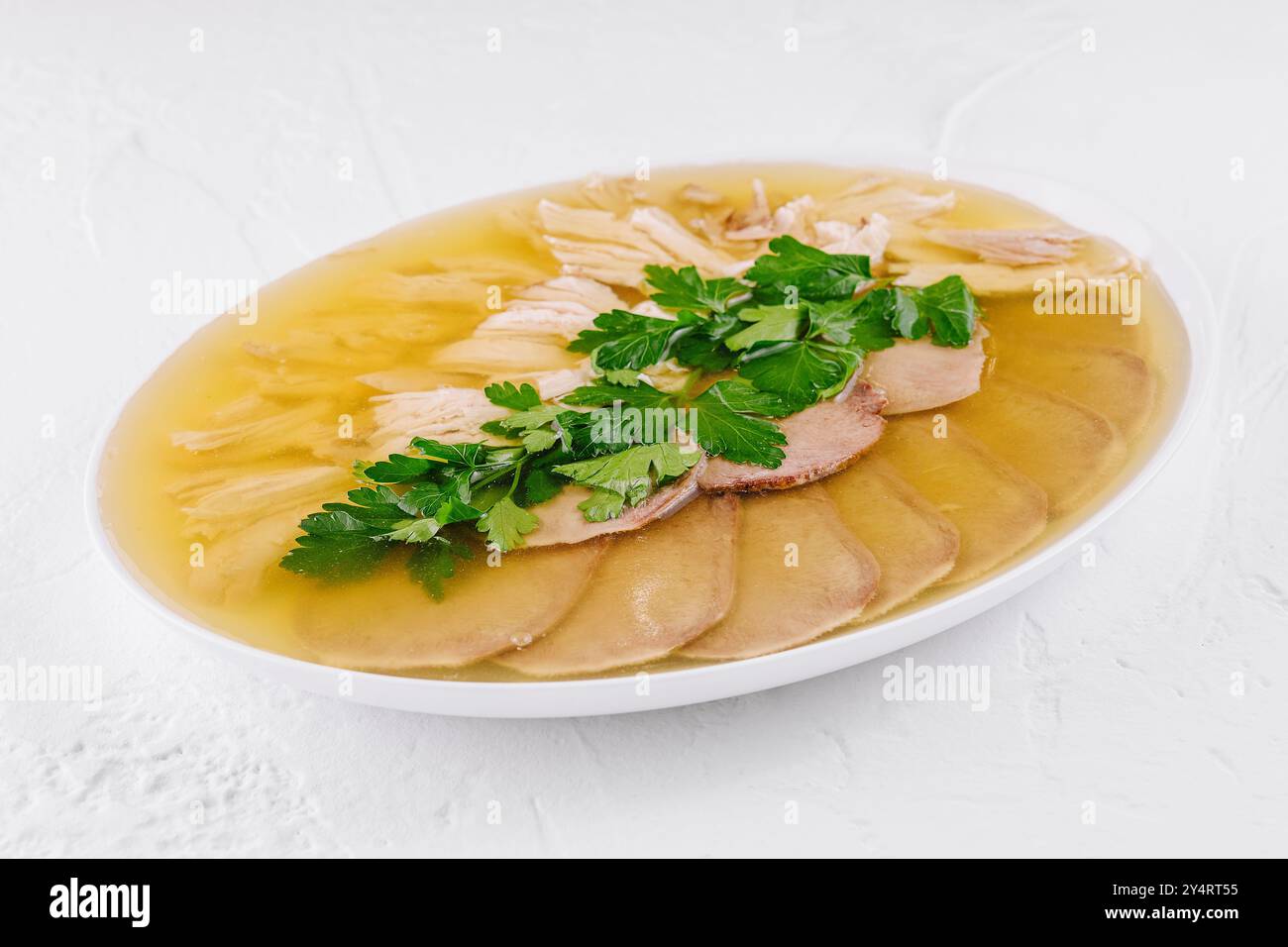 homemade chicken aspic with meat slices and fresh parsley on white ...