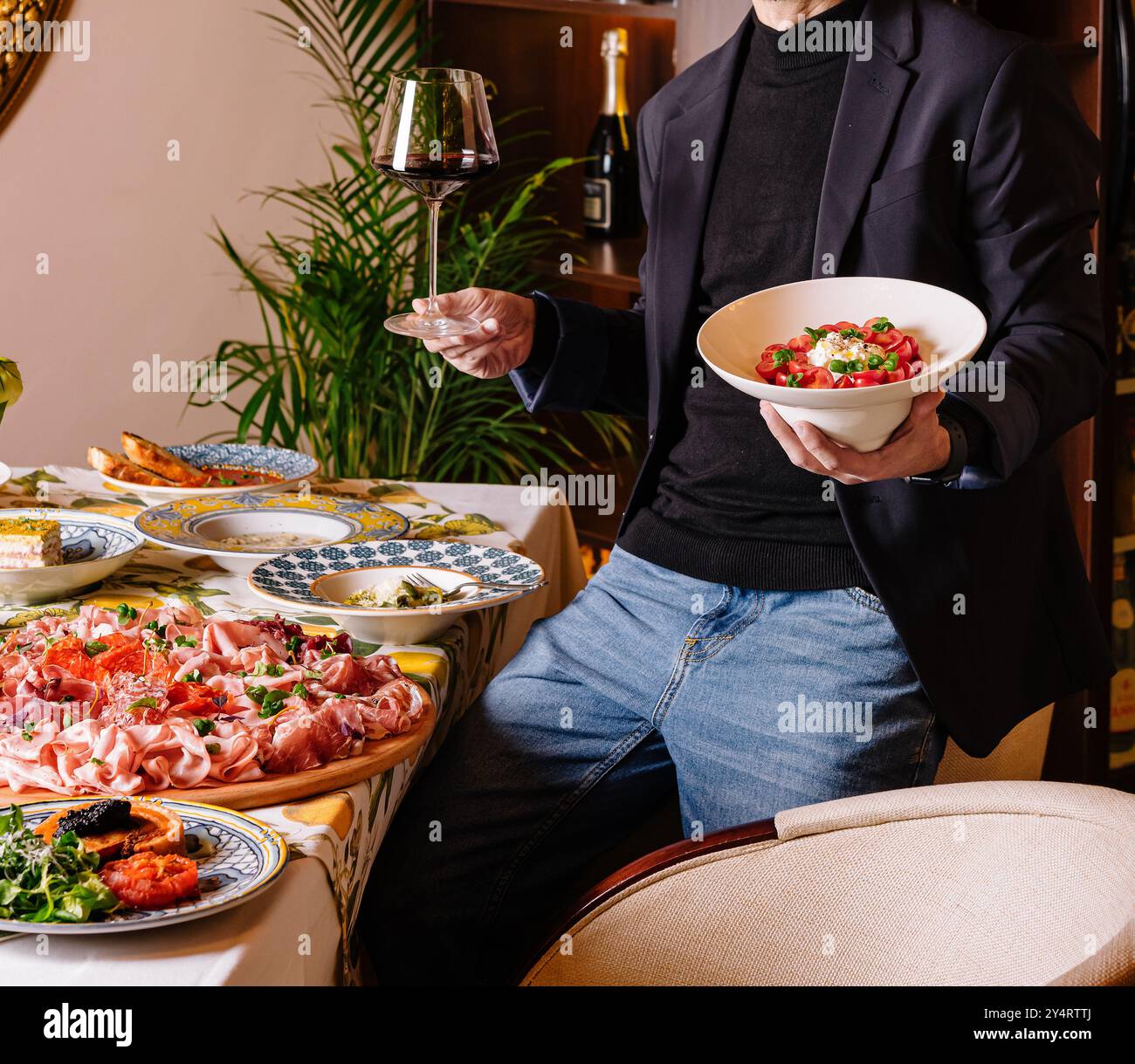 Well-dressed man serving himself salad at a luxurious buffet with ...