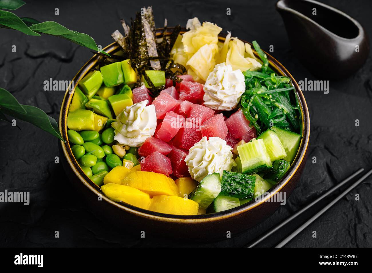 Colorful poke bowl featuring raw tuna, avocado, mango, and mixed ...
