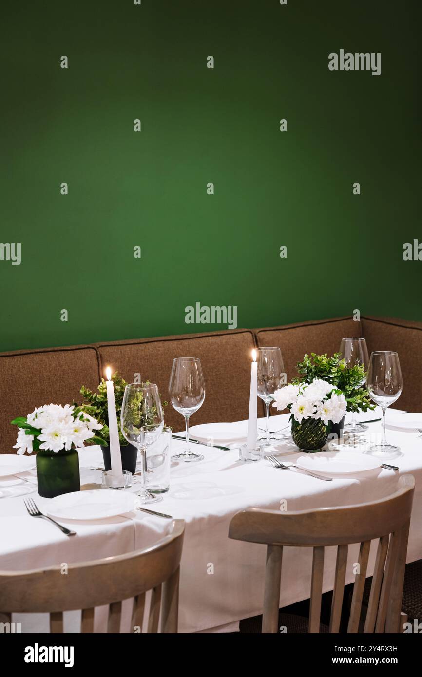 Cozy dining table setup with lit candles, fresh flowers, and elegant ...