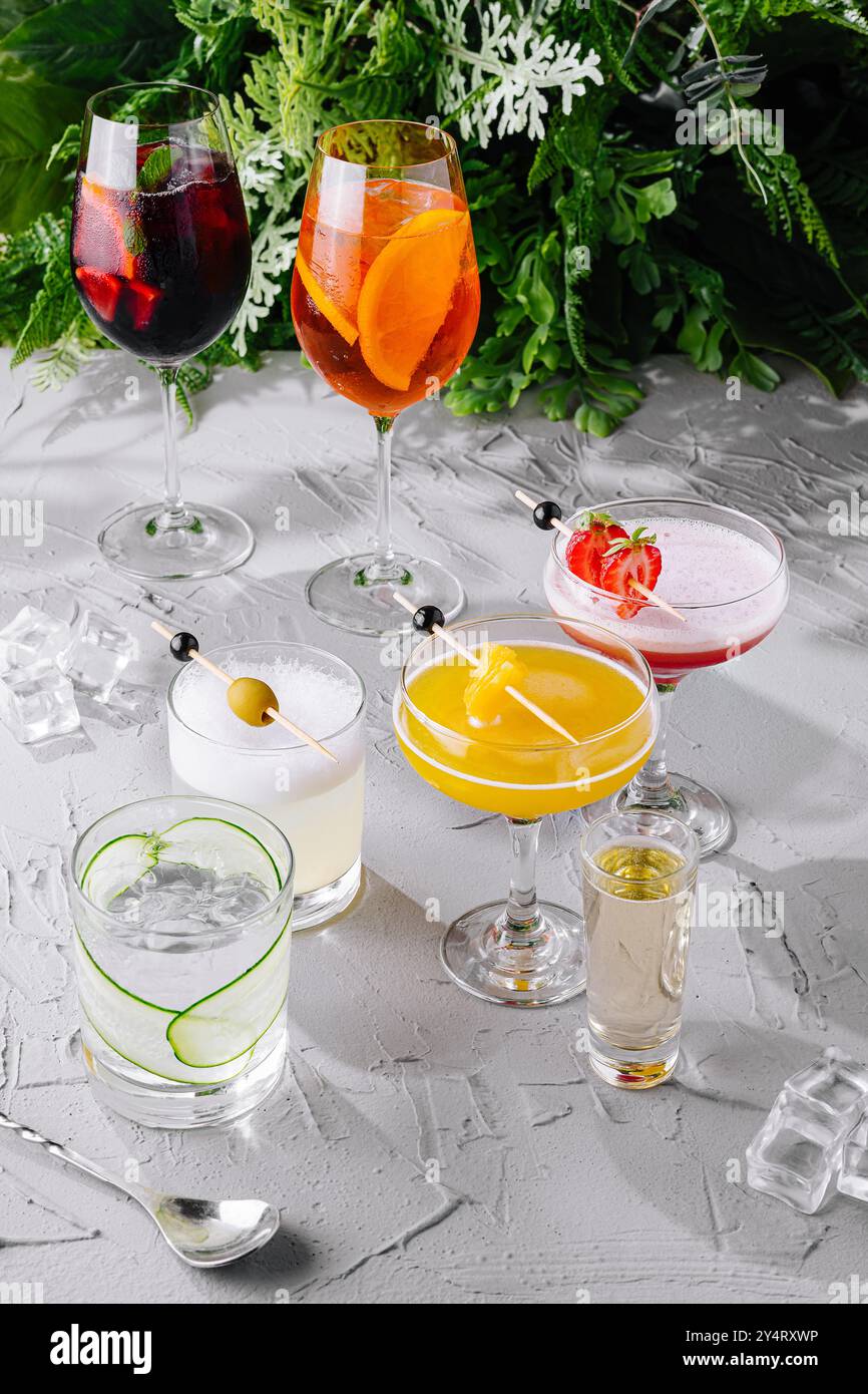 Variety of refreshing cocktails with garnishes arranged on a table with ...
