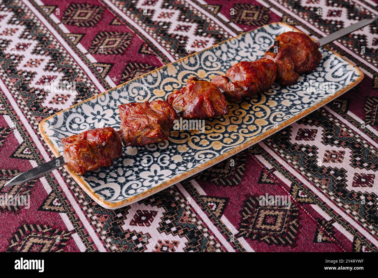 Traditional turkish kebab skewer served on an ornate plate with ethnic ...