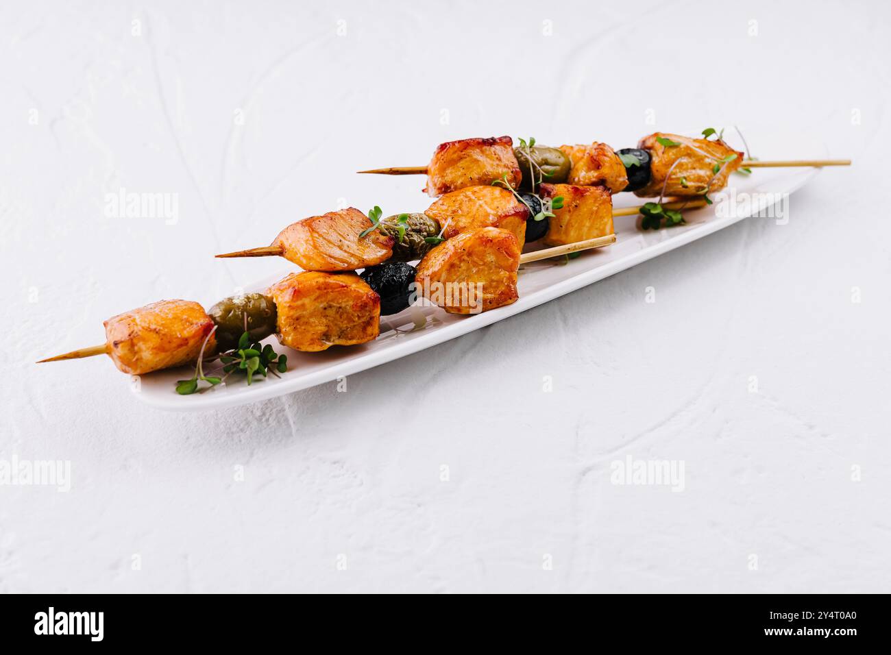 Elegant presentation of chicken skewers garnished with herbs on a sleek ...