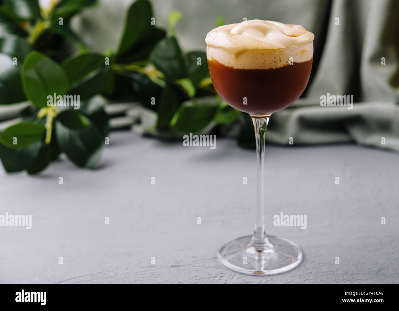 Espresso martini with a creamy foam topping, presented in a stemmed ...