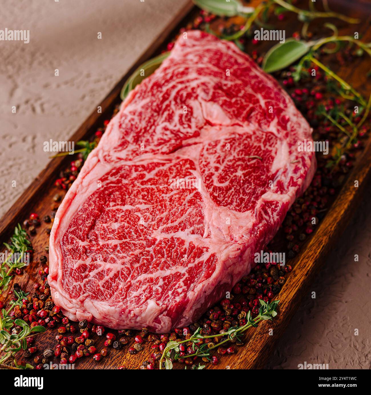 Marbled ribeye steak adorned with herbs and spices hi-res stock ...