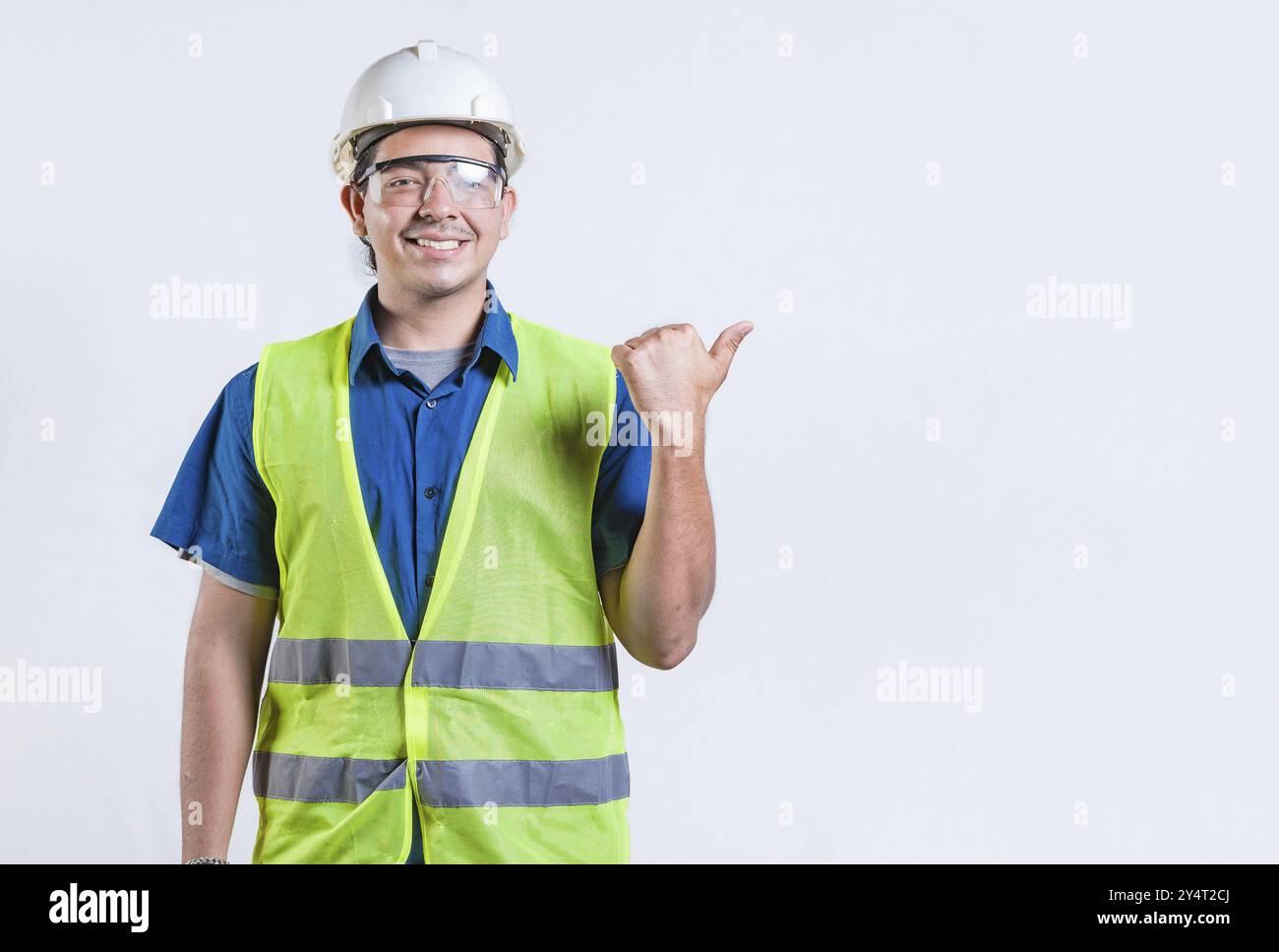 Portrait of engineer man pointing to side isolated. Smiling engineer ...