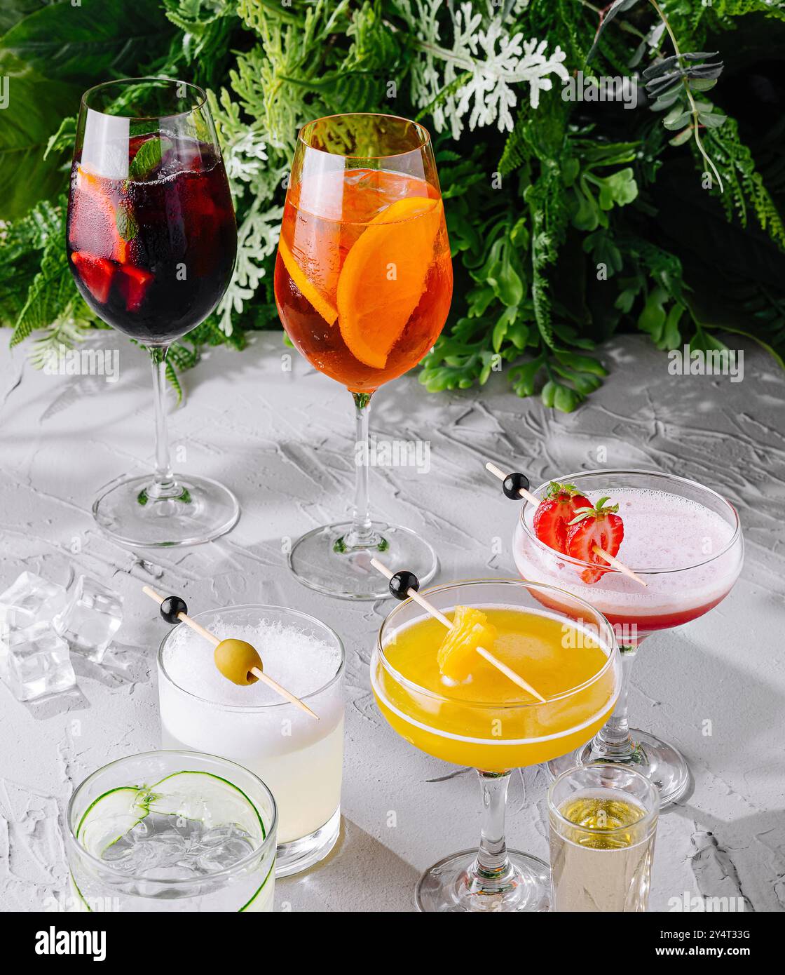 Variety of refreshing cocktails with garnishes arranged on a table with ...