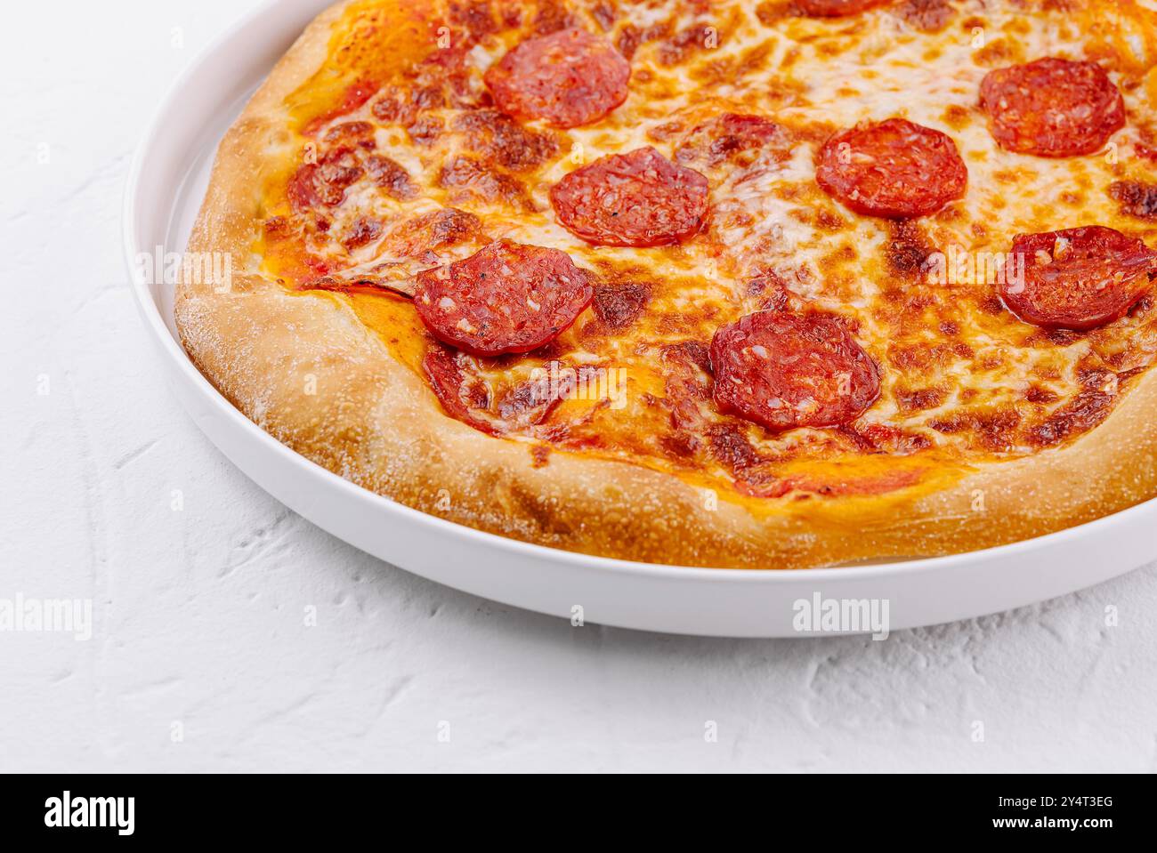 Delicious classic pepperoni pizza served on a ceramic plate against a ...
