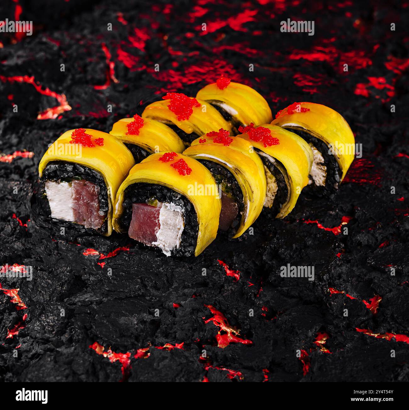 Artistic sushi presentation with a roll on a dramatic black and red ...