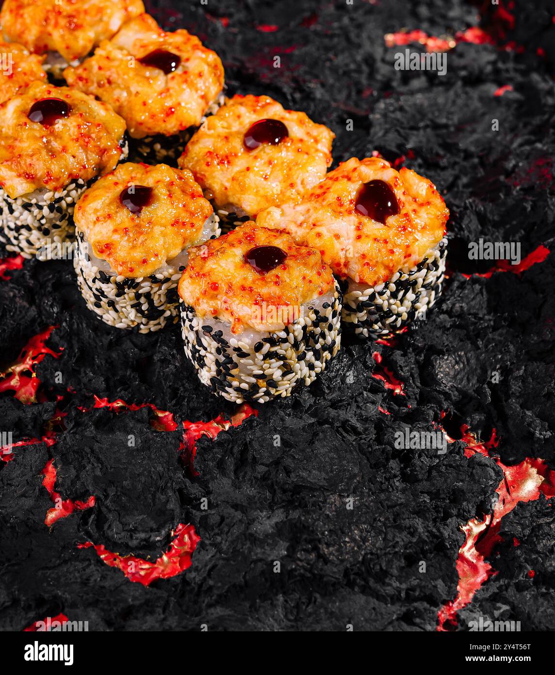 Artful presentation of a volcano sushi roll set on a dramatic black and ...