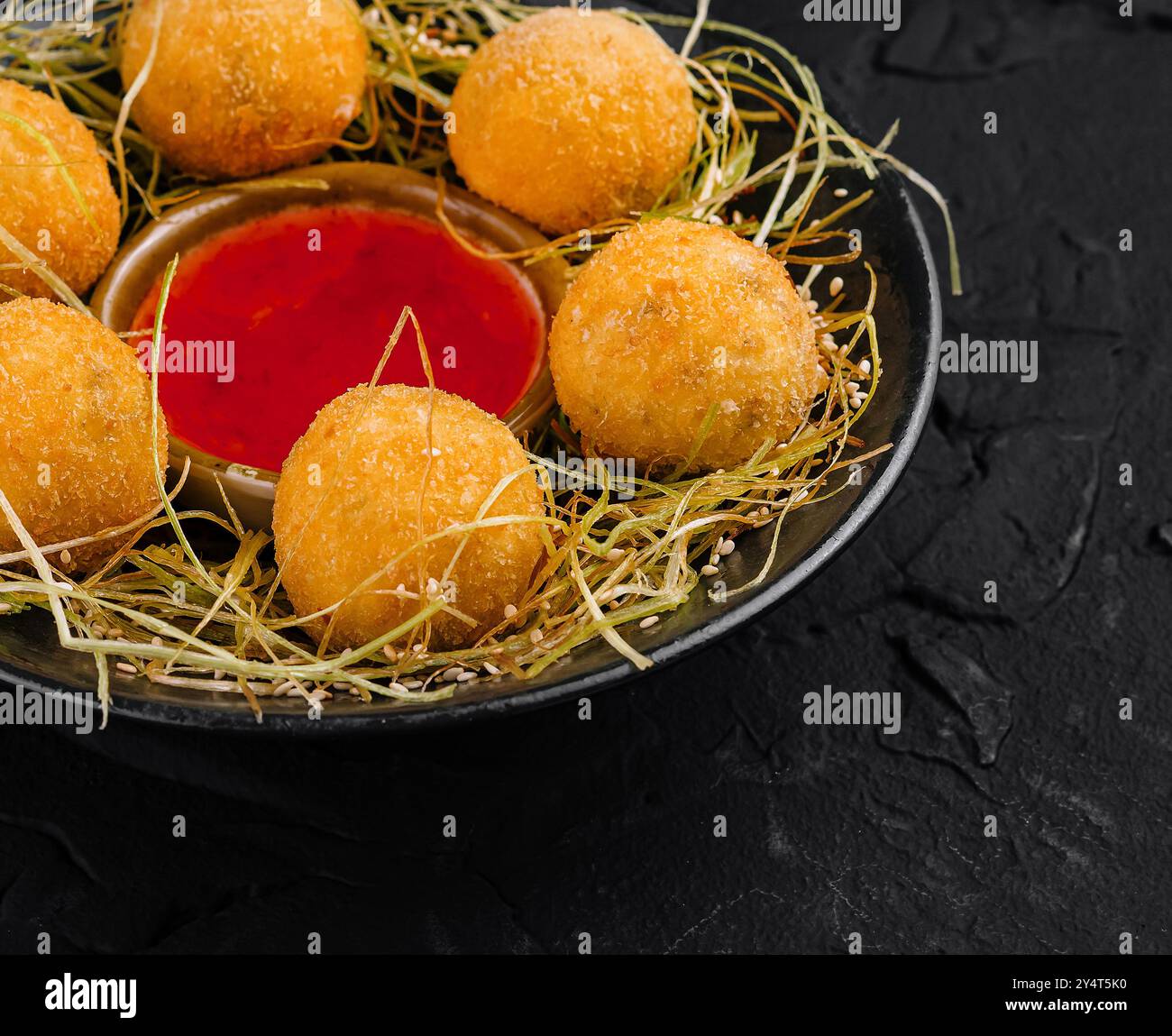 Gourmet fried cheese balls served with dipping sauce on a rustic hay ...