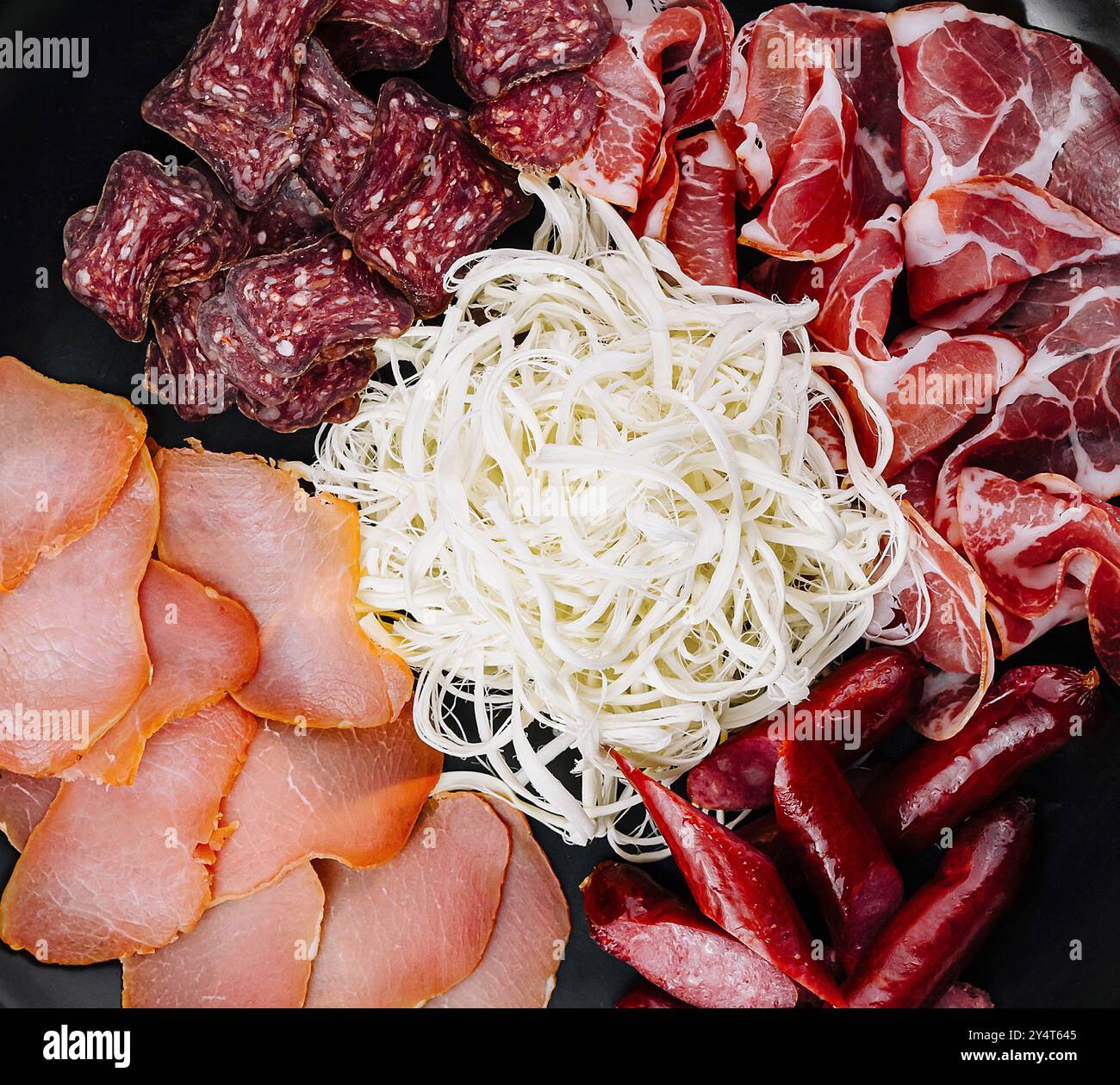 Overhead view of a charcuterie selection with meats and cheese on a ...