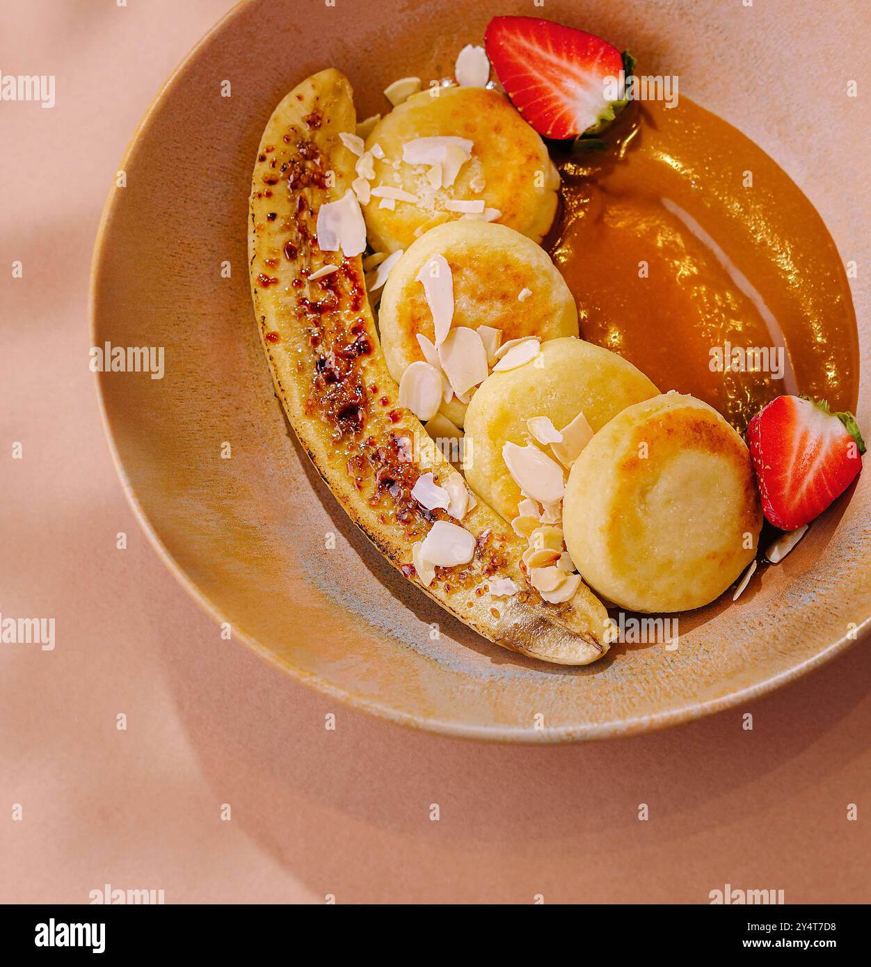 Elegant plated breakfast with pancakes, banana, strawberries, and ...