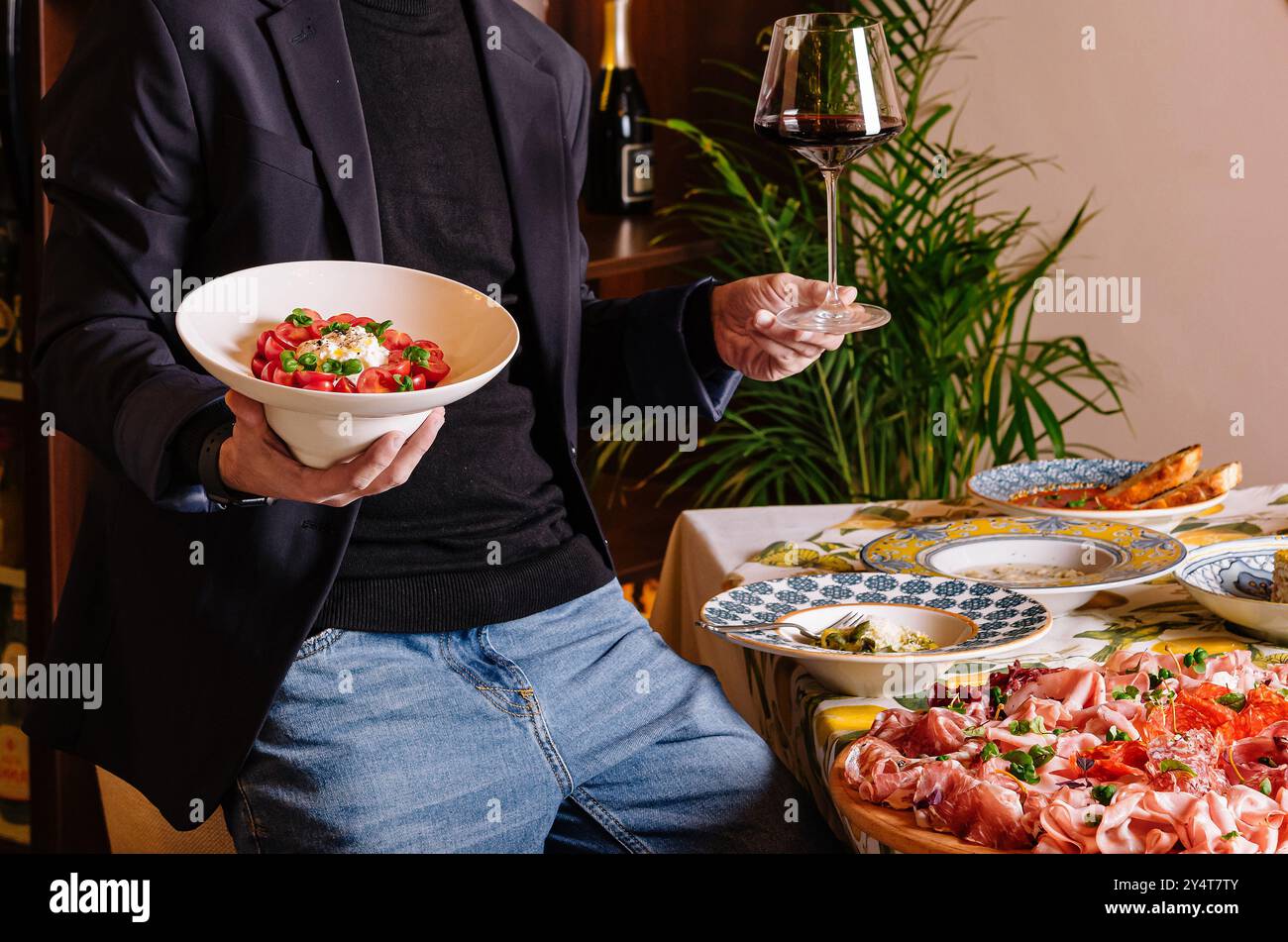 Well-dressed man serving himself salad at a luxurious buffet with ...