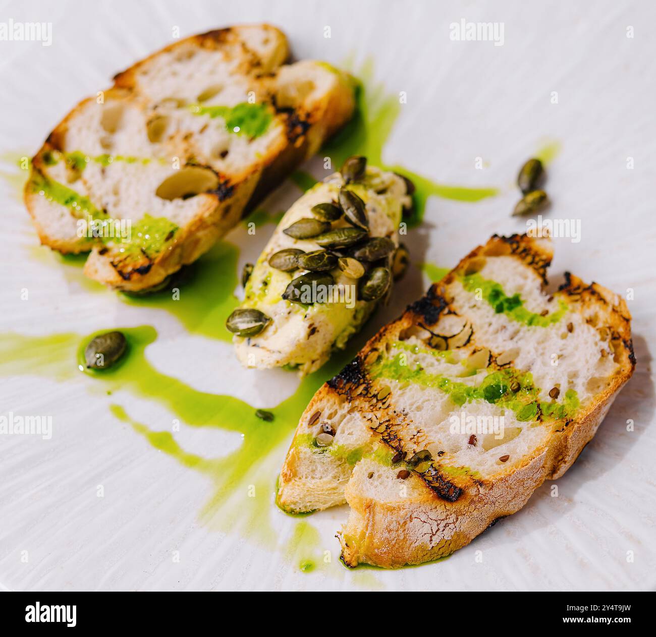 Elegant plating of avocado toast with capers and drizzle of herb oil on ...