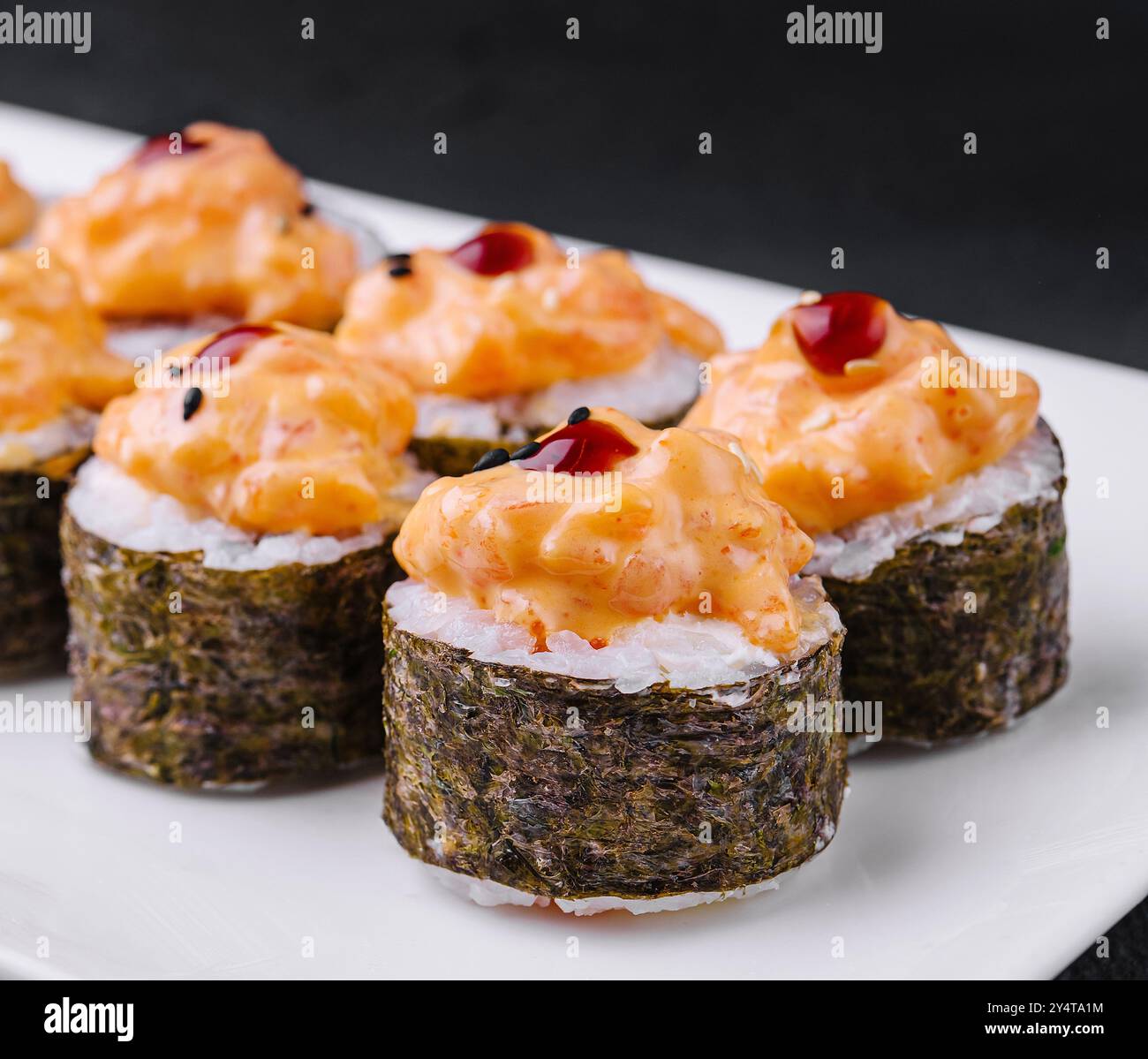 Fresh spicy shrimp sushi rolls served on a modern white plate with a ...
