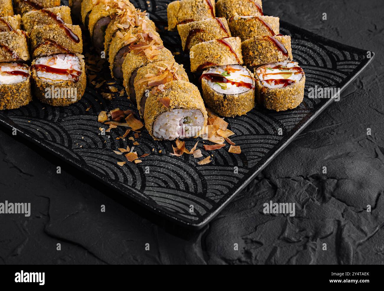 Gourmet sushi rolls with diverse toppings and fillings on a chic black ...