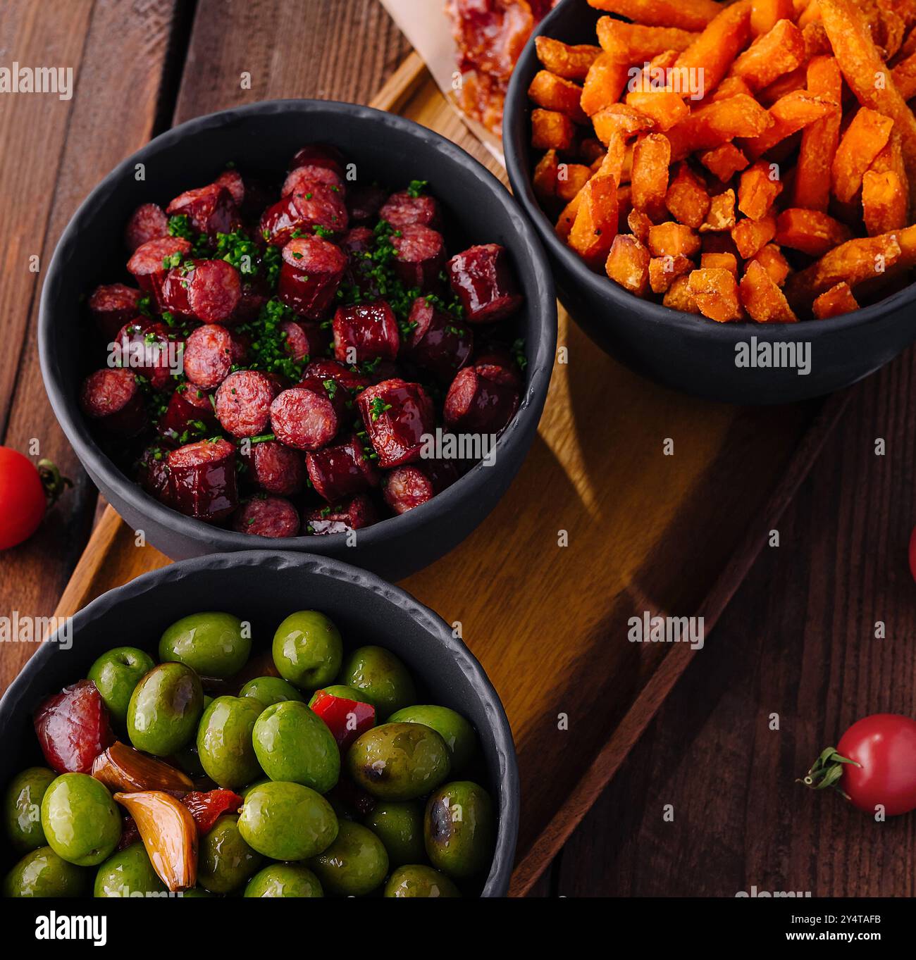 Vibrant spread of tapas including green olives, spicy sausage, and ...