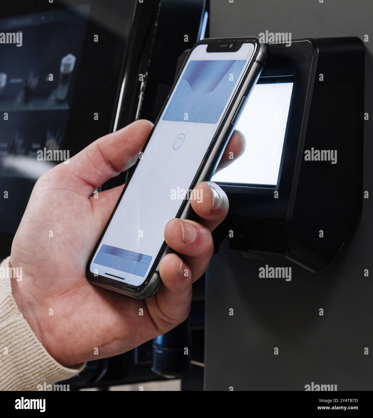 Person using a smartphone to make a contactless payment at an ...