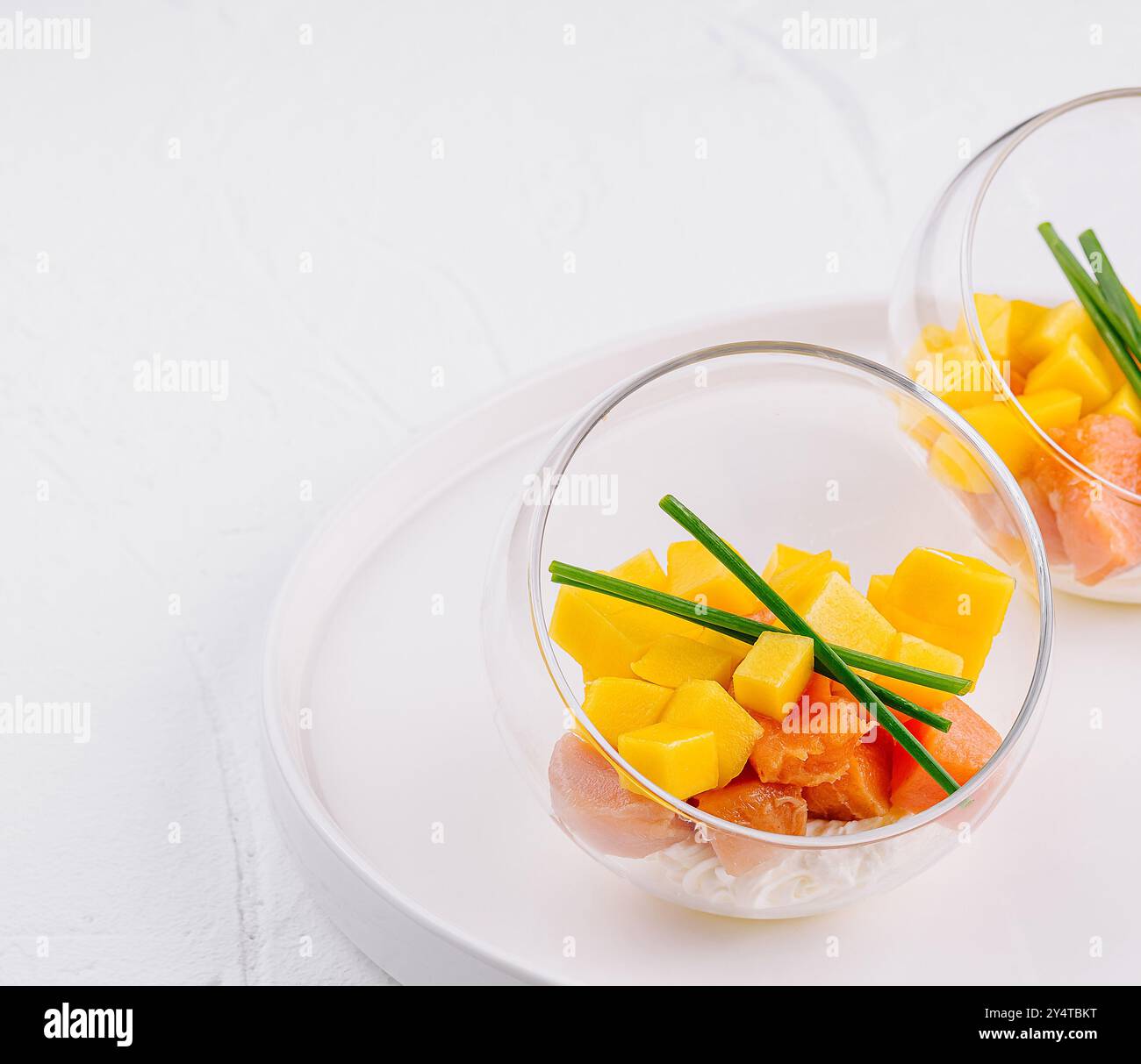 Elegant presentation of salmon and mango tartare with chive garnish in ...