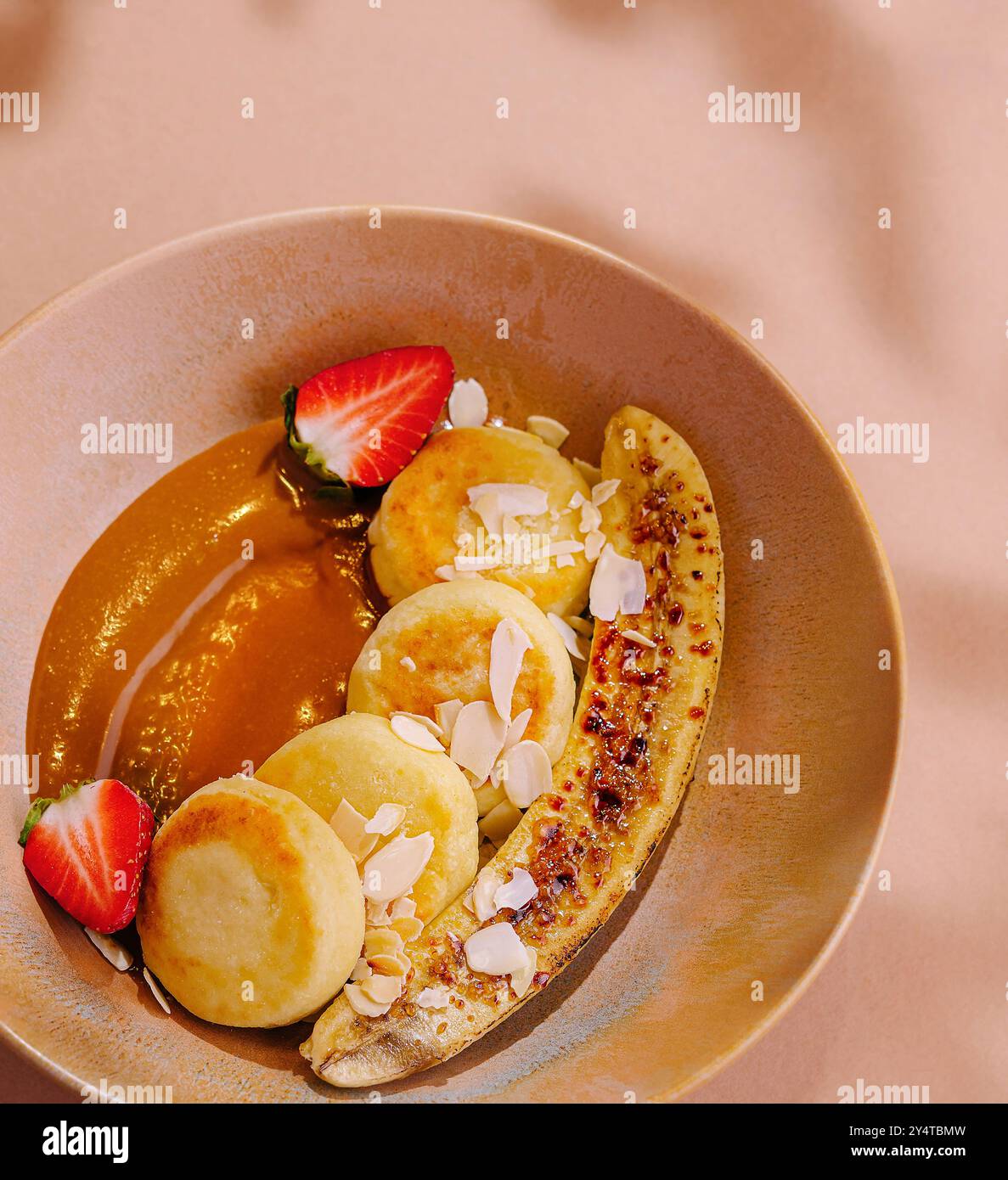 Elegant plated breakfast with pancakes, banana, strawberries, and ...