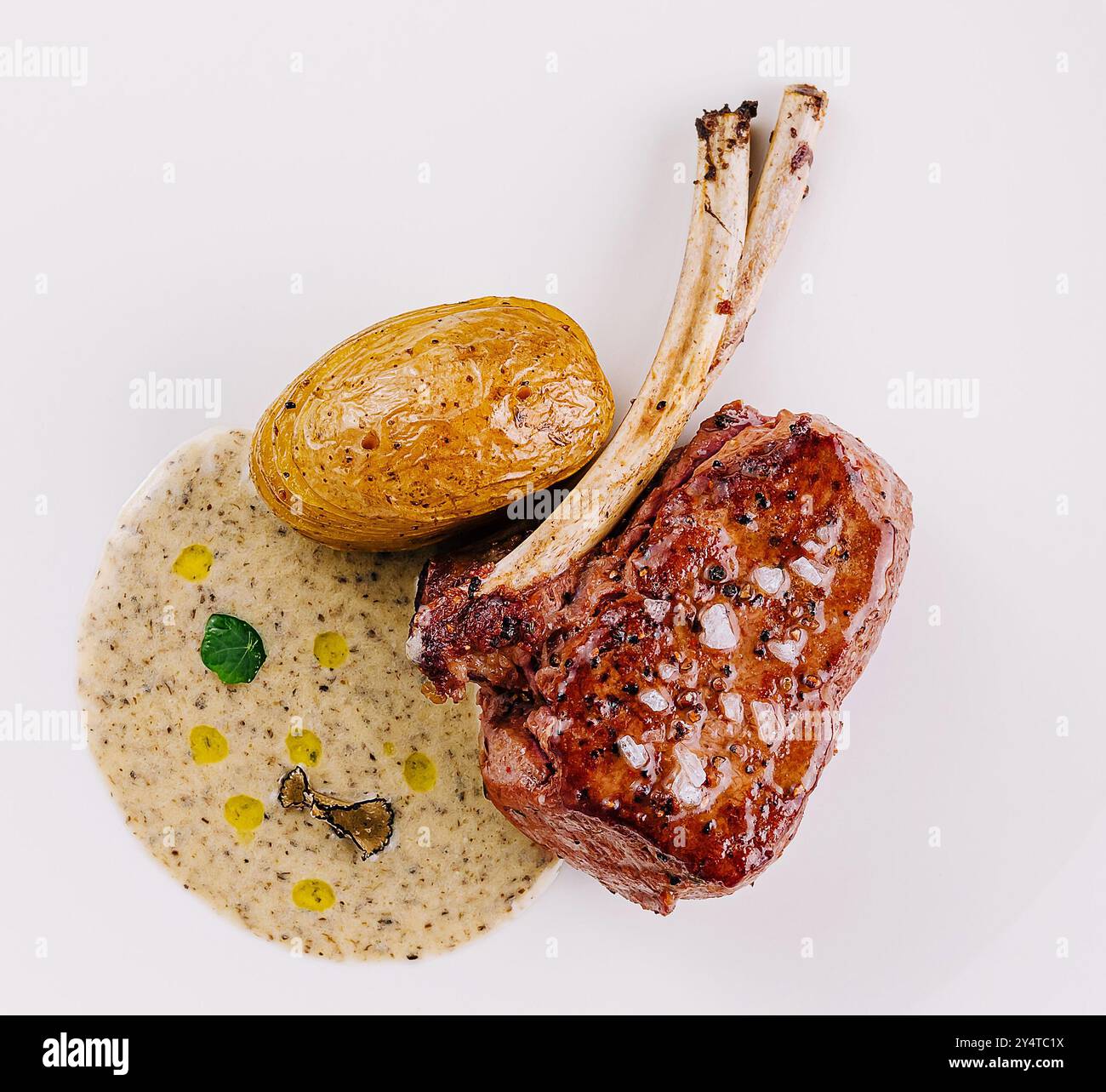 Elegant plating of a juicy lamb chop with golden roasted potatoes on a ...