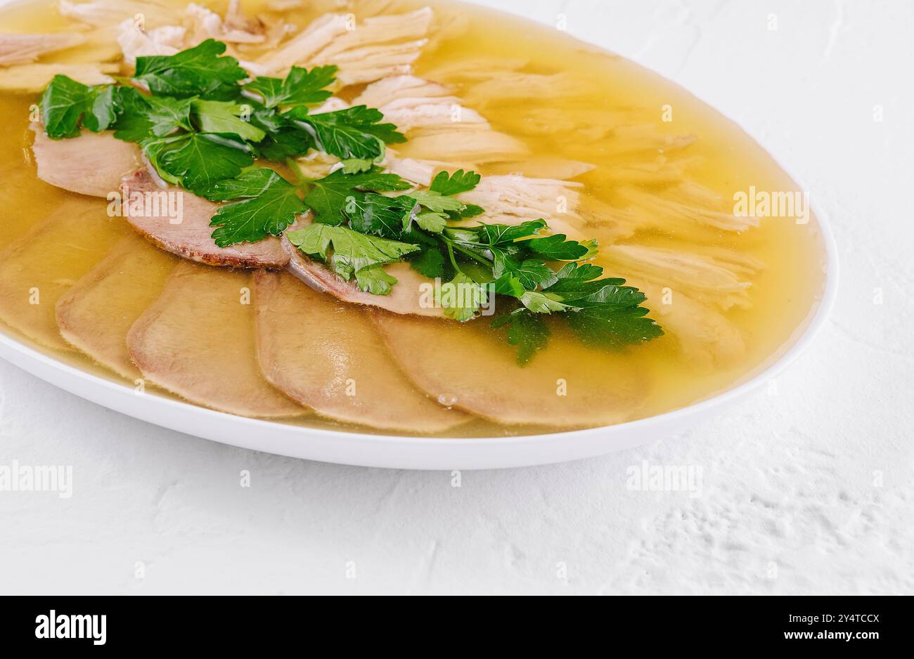 homemade chicken aspic with meat slices and fresh parsley on white ...