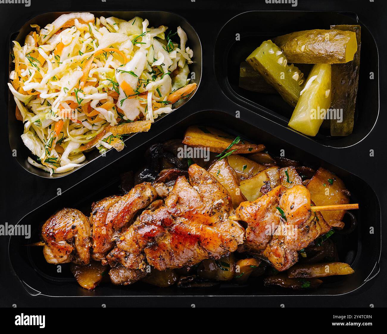 Top view of a healthy grilled chicken meal prep with sides in a black ...