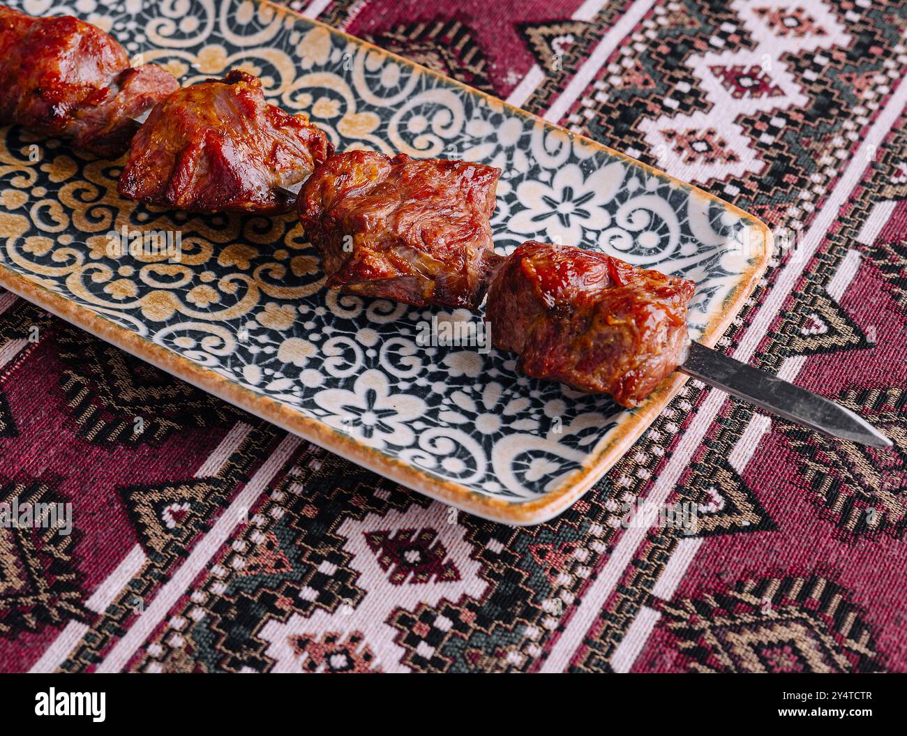 Traditional turkish kebab skewer served on an ornate plate with ethnic ...