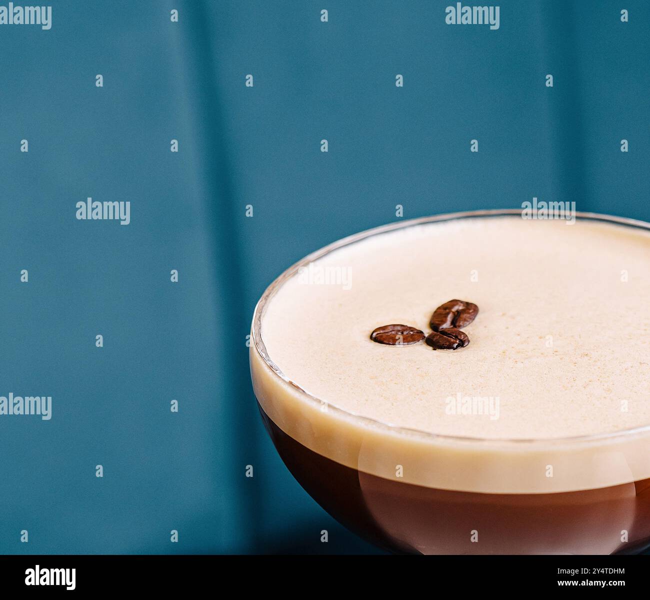 Stylish espresso martini with coffee beans garnish, served on a white ...