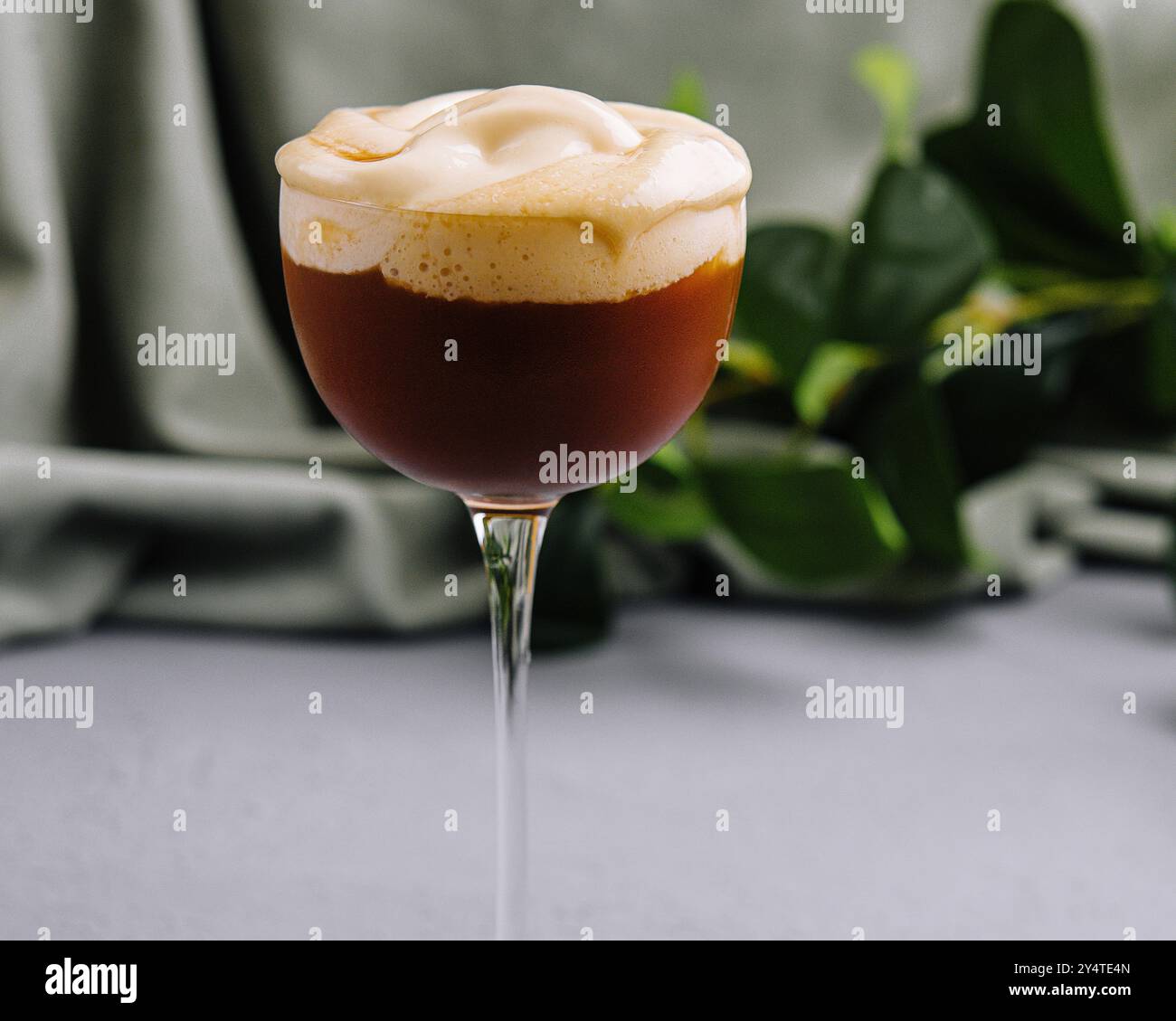 Espresso martini with a creamy foam topping, presented in a stemmed ...