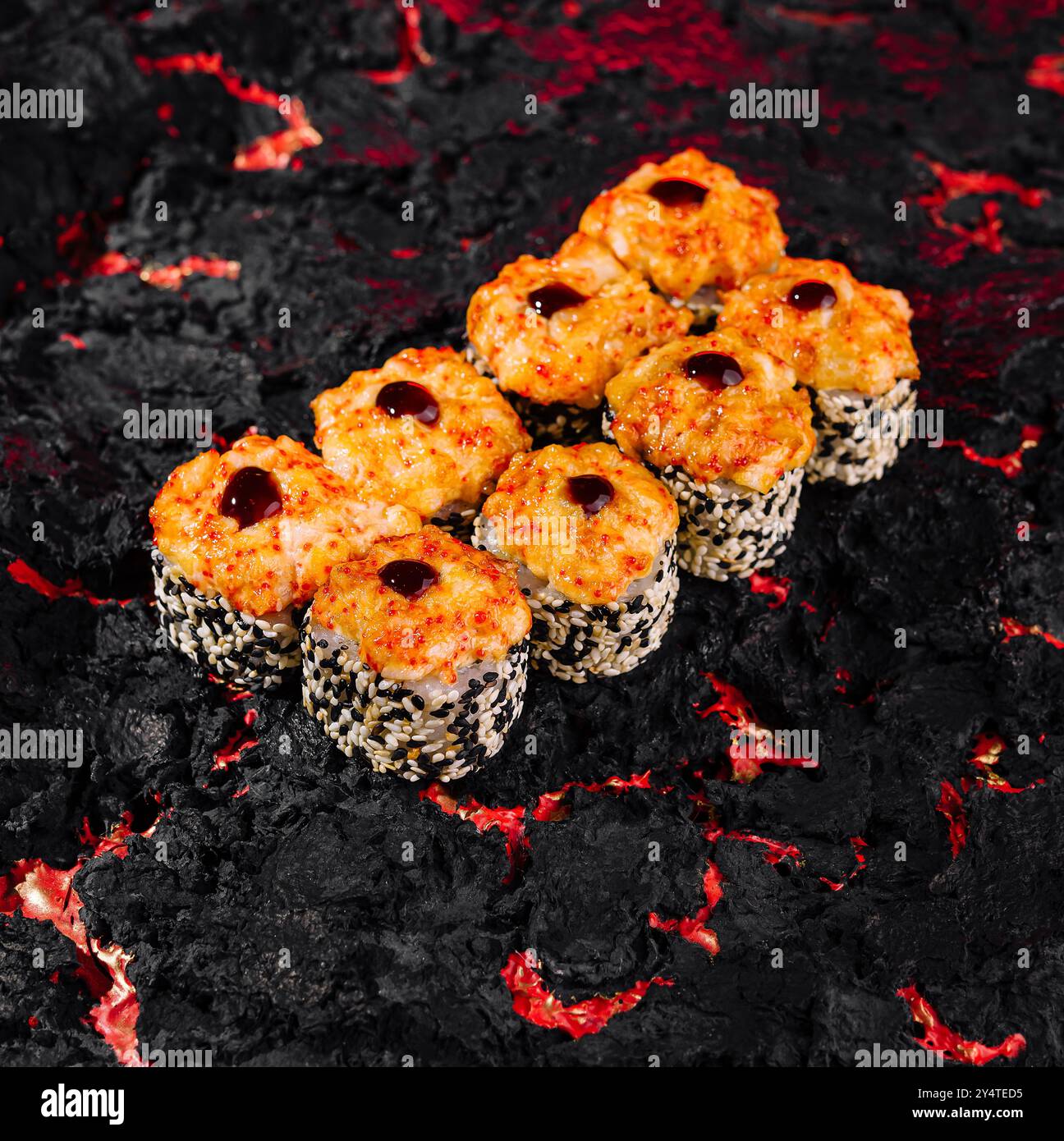 Artful presentation of a volcano sushi roll set on a dramatic black and ...