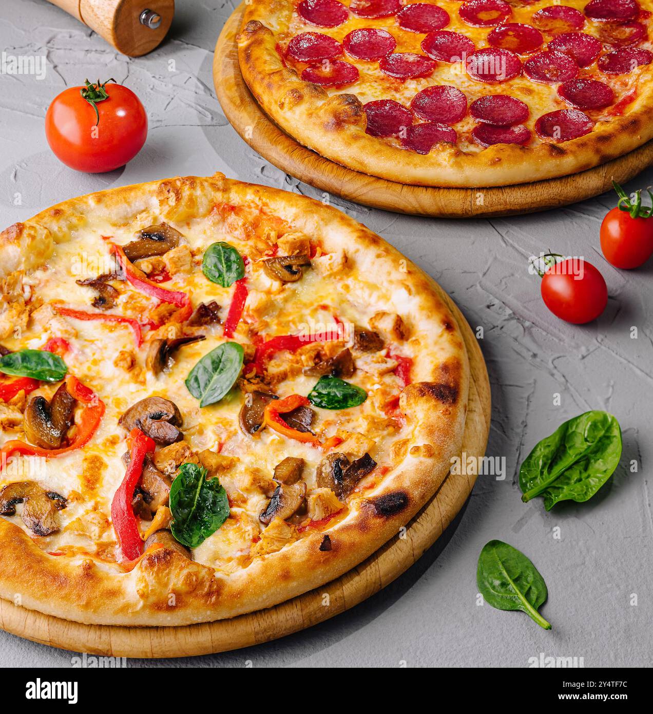Two tasty pizzas with pepperoni and vegetables, fresh ingredients on a ...