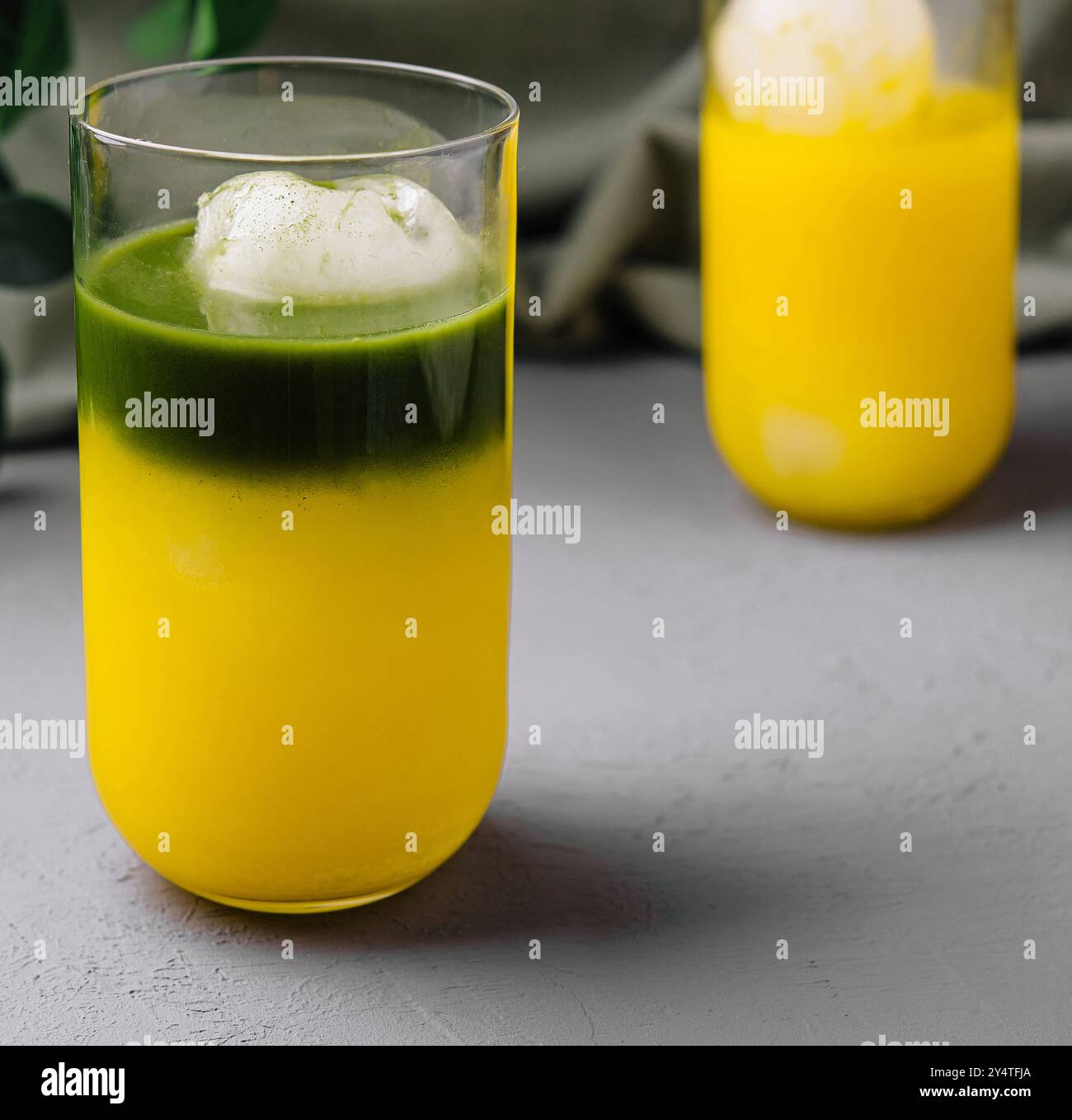 Vibrant green matcha float beside a glass of fresh mango juice on a ...