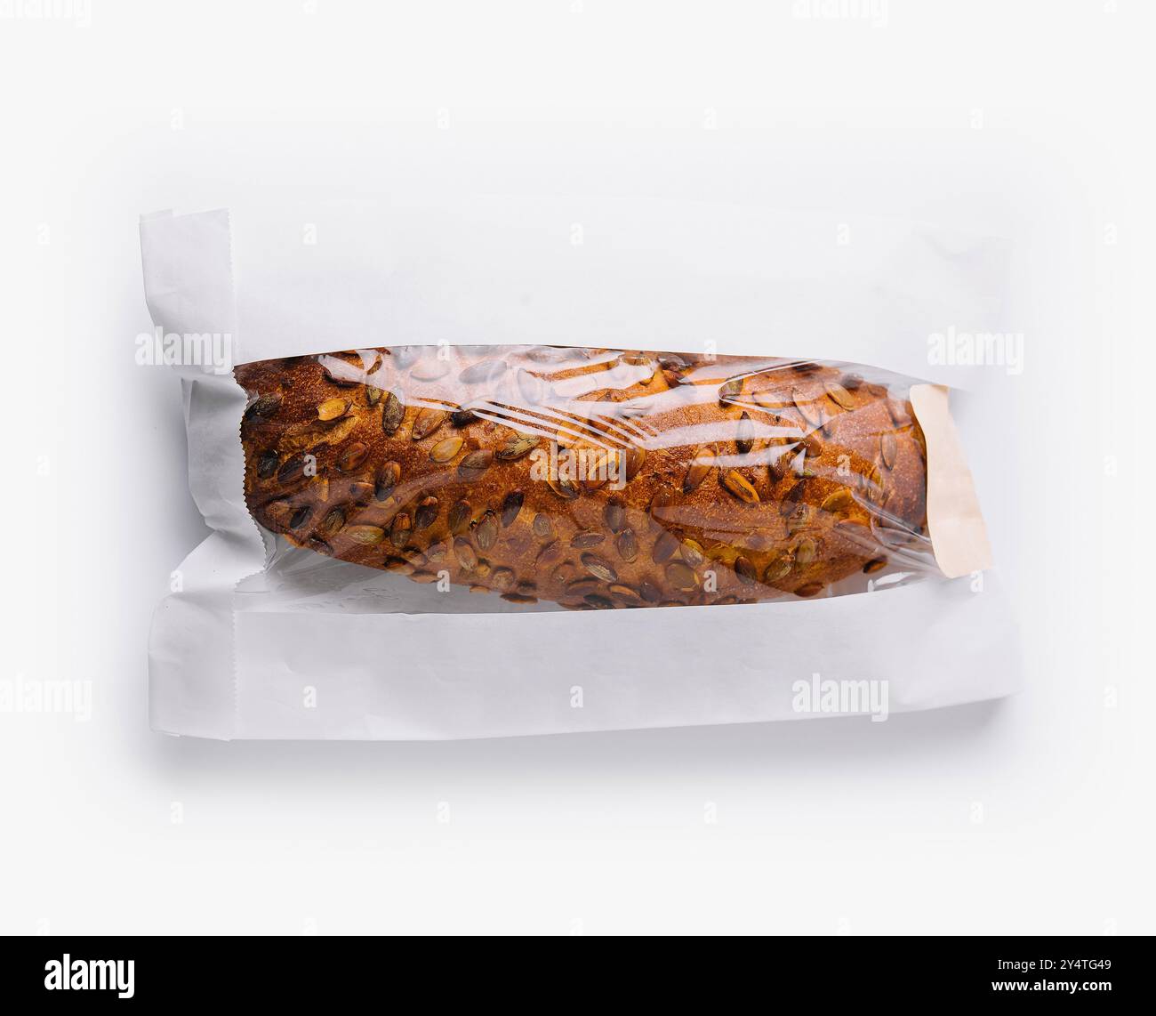 Top view of a rustic, crusty loaf of bread wrapped in a paper bag on a ...
