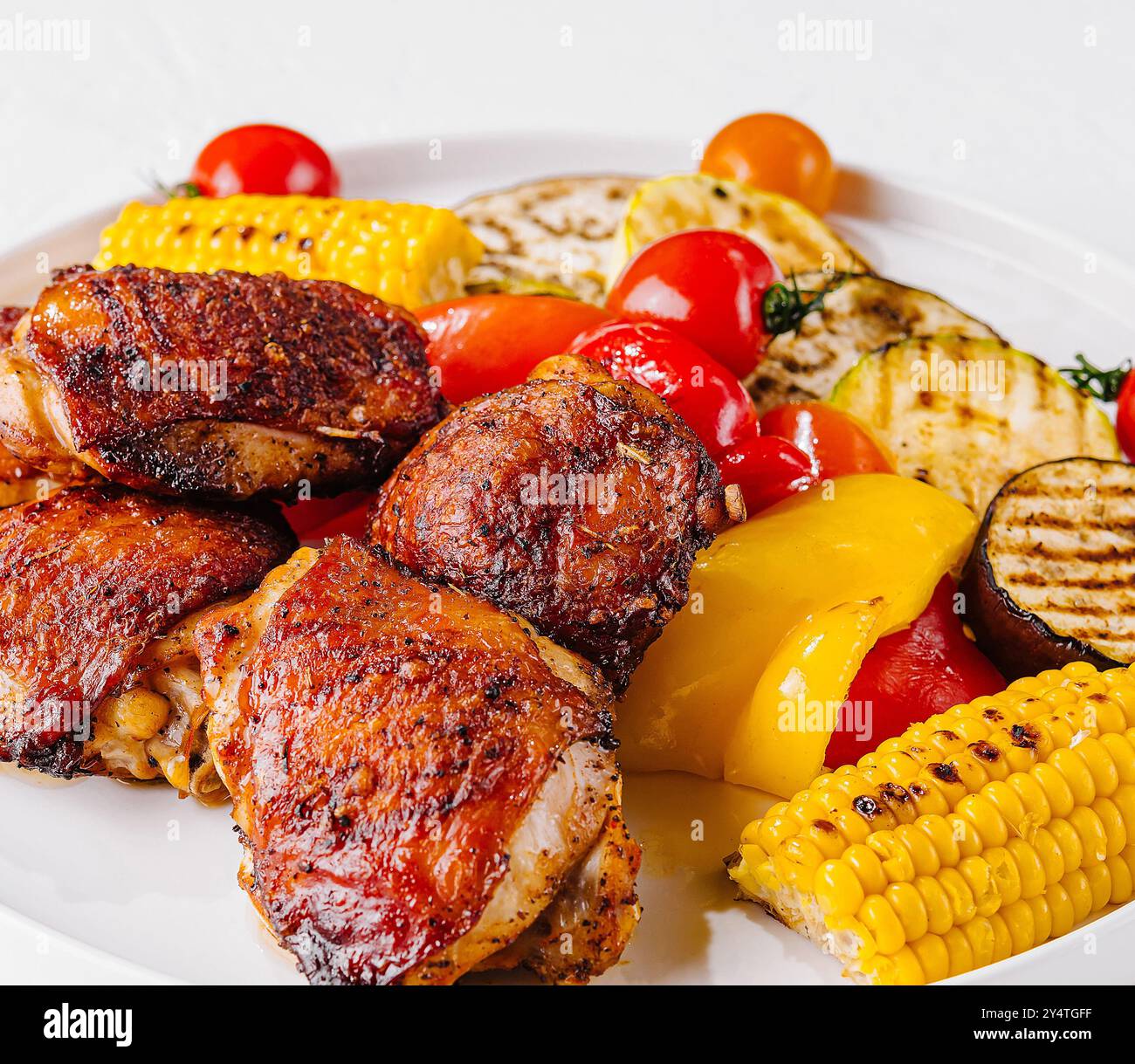 Succulent grilled chicken thighs alongside roasted corn, peppers ...