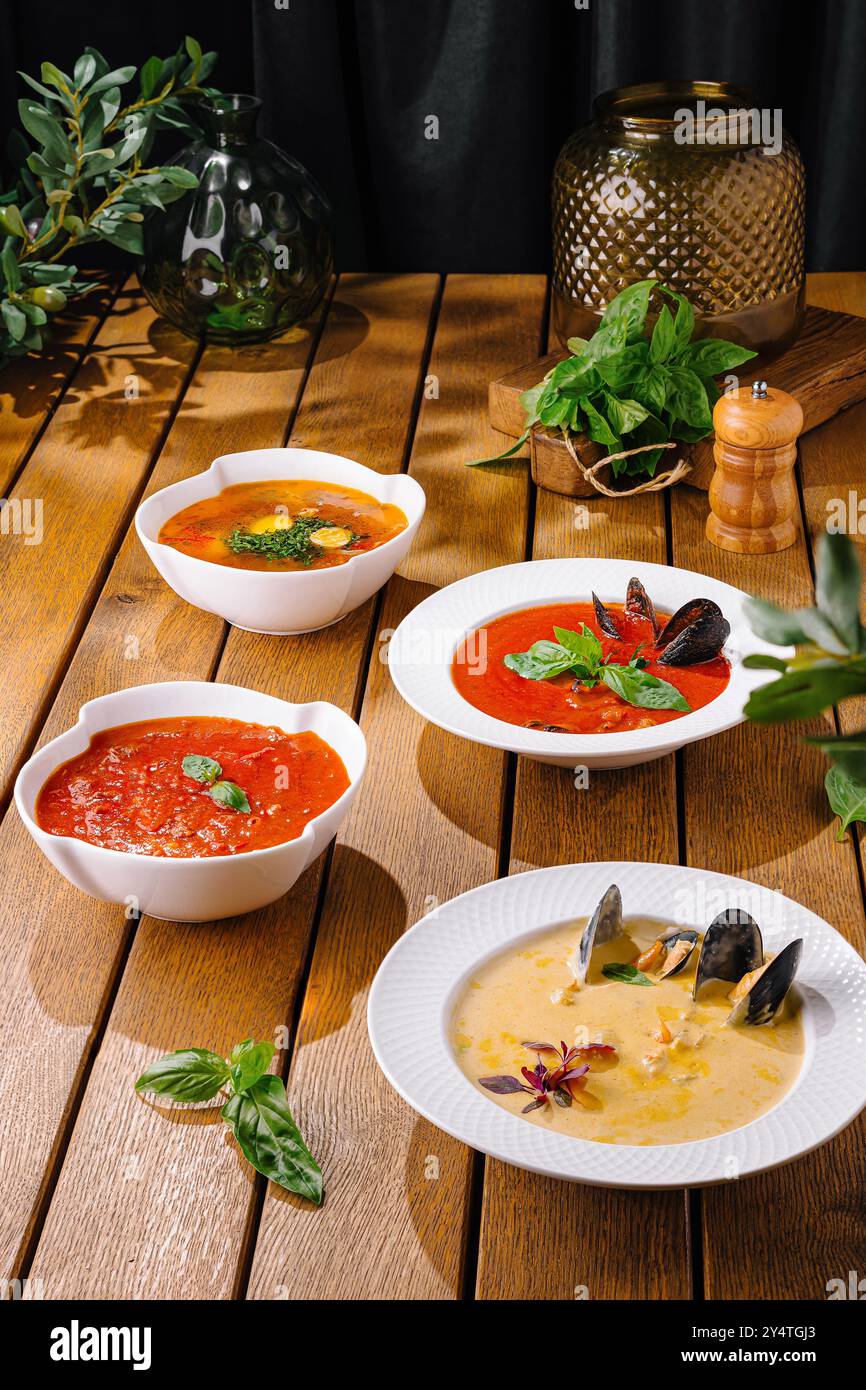 Elevated view of three delicious soup varieties served in white bowls ...