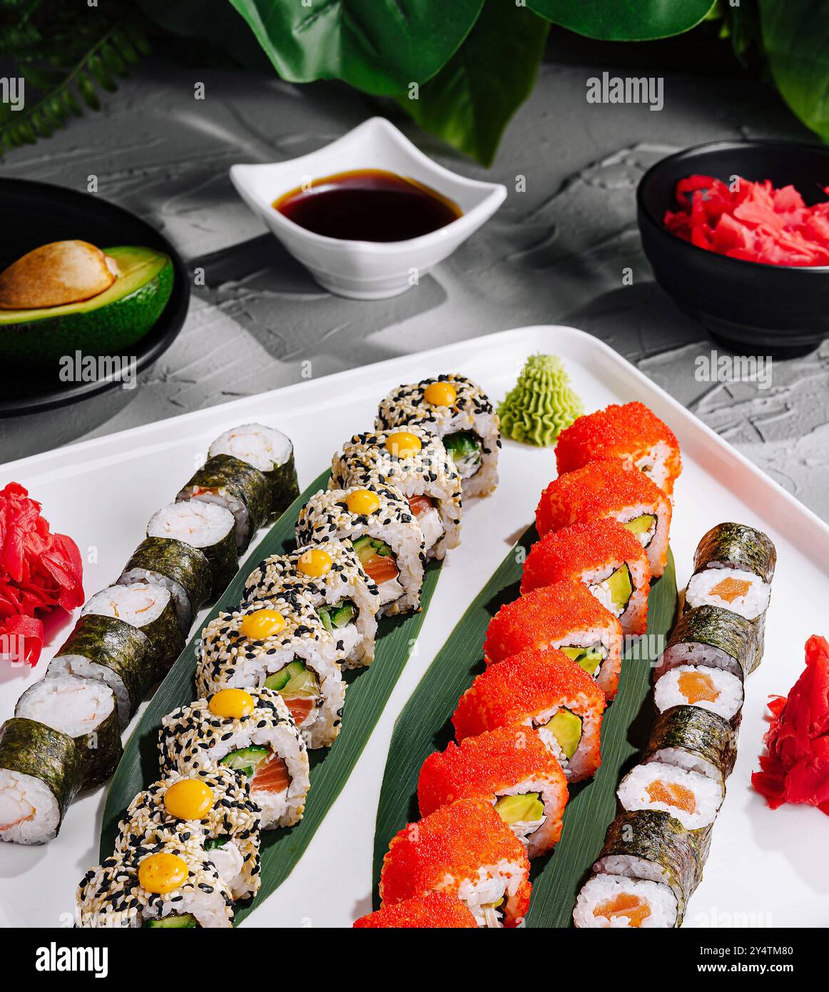 Vibrant platter of diverse sushi rolls garnished and ready to serve on ...