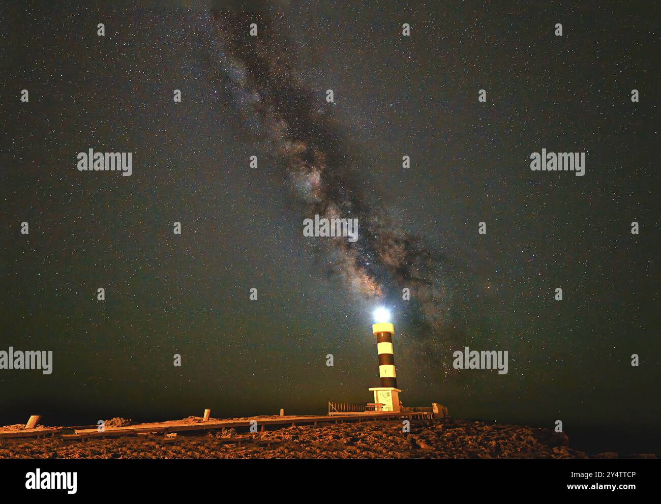Lighthouse at night under a clear starry sky with the Milky Way ...